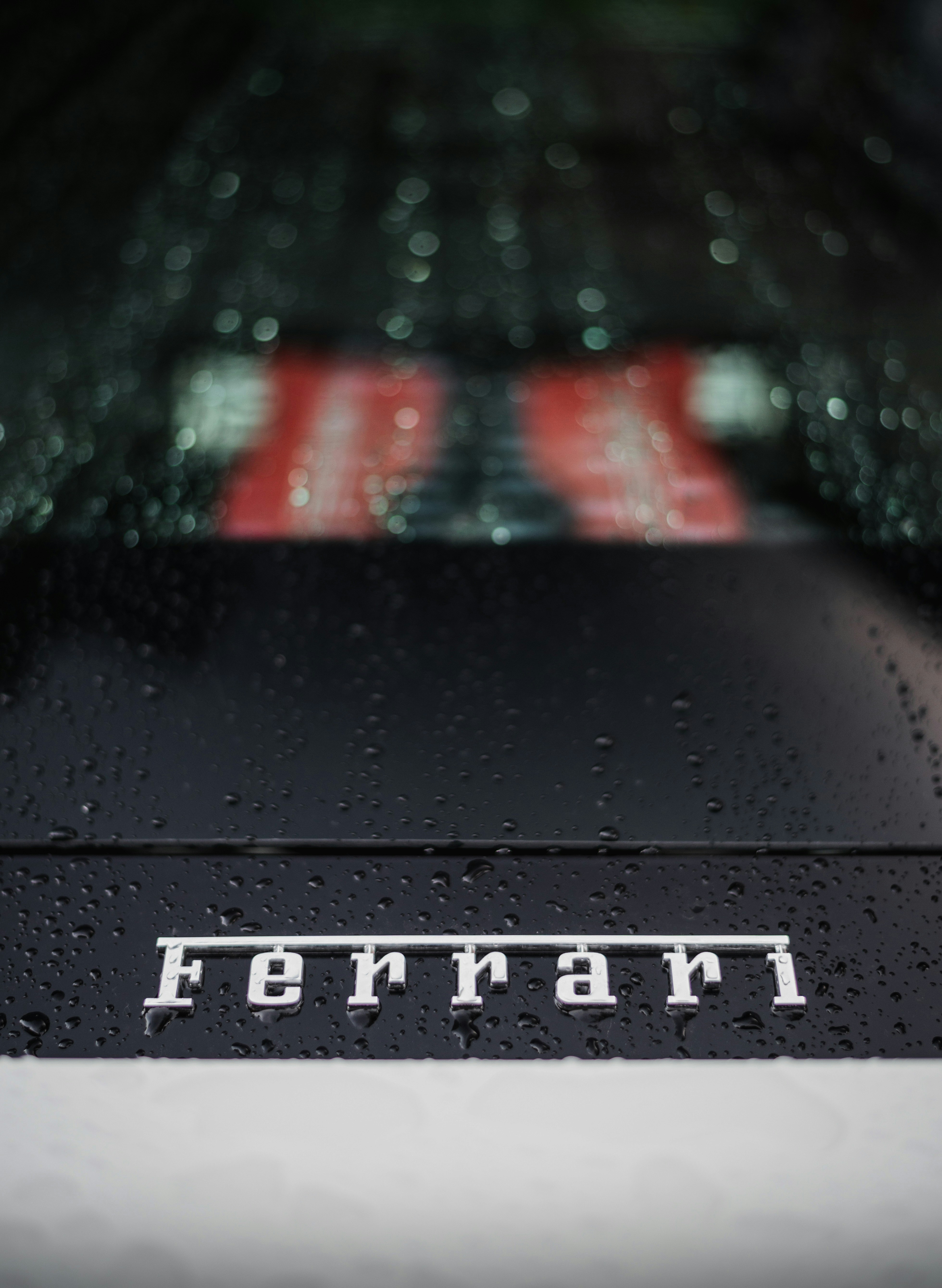 Ferrari Emblem in Rain: A Close-Up on Gloss and Droplets
