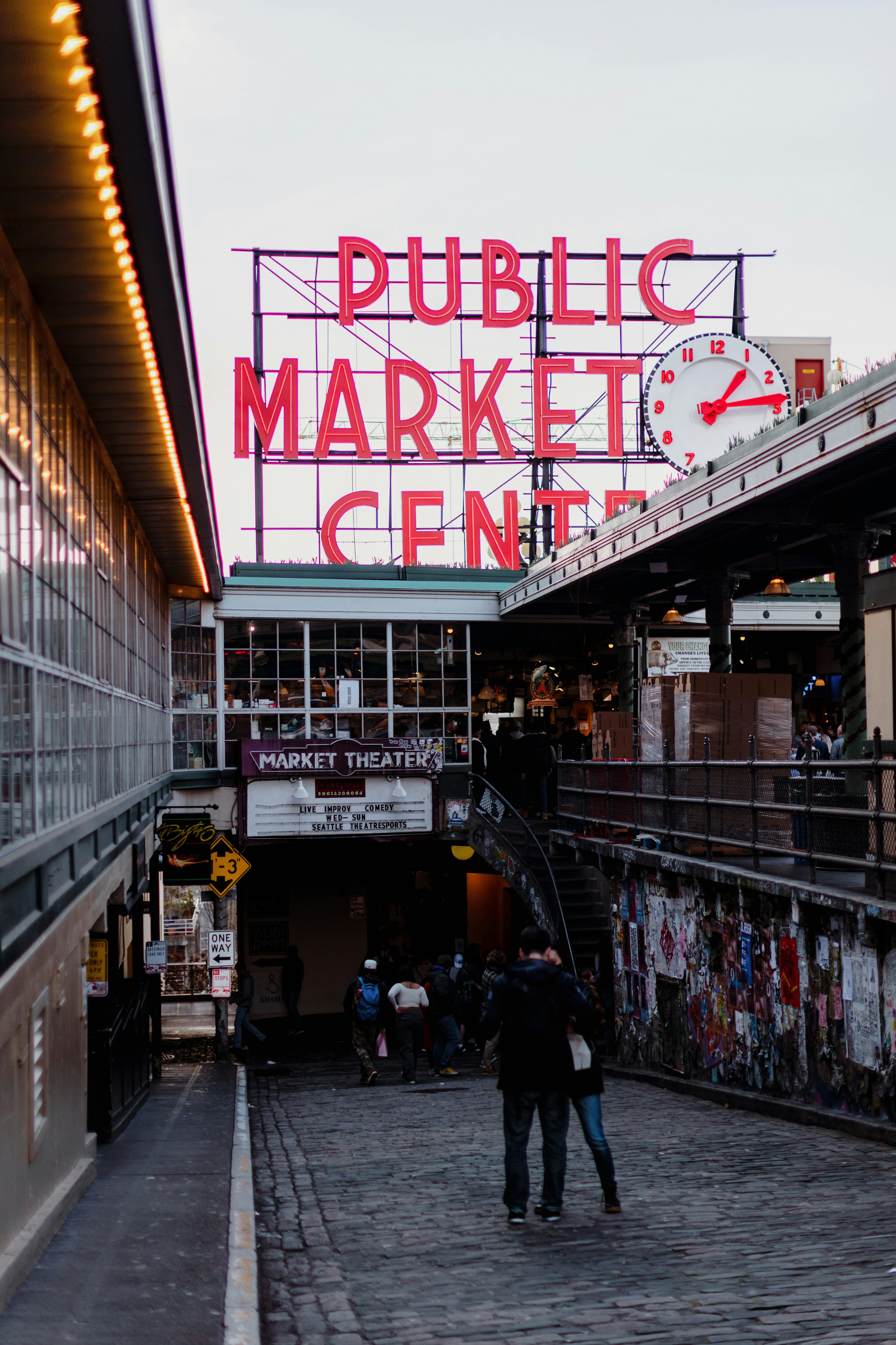 Neon Public Market Sign Overlooking a Cobblestone Lane