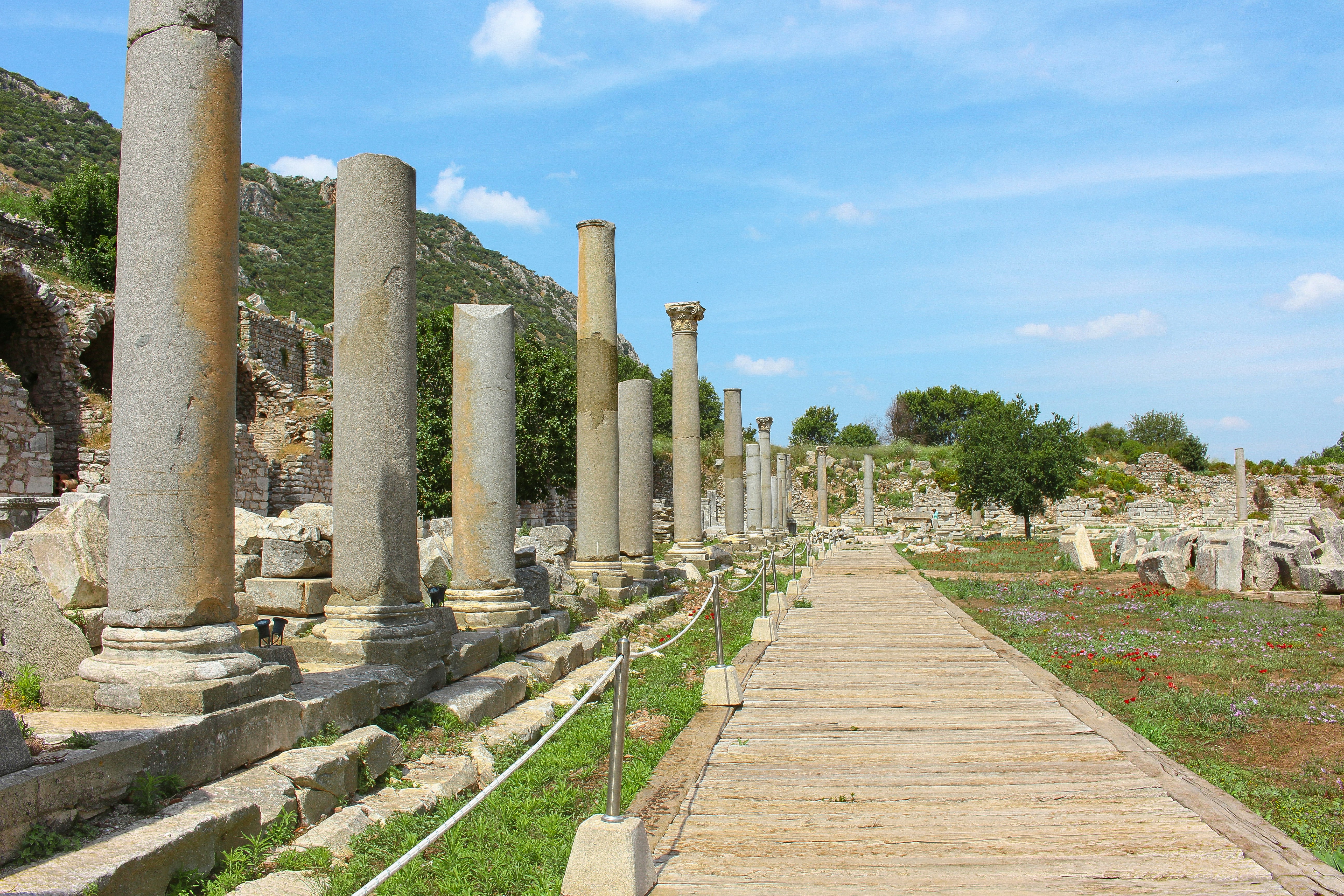 A long walkway between two large stone pillars photo – Free Marble ...