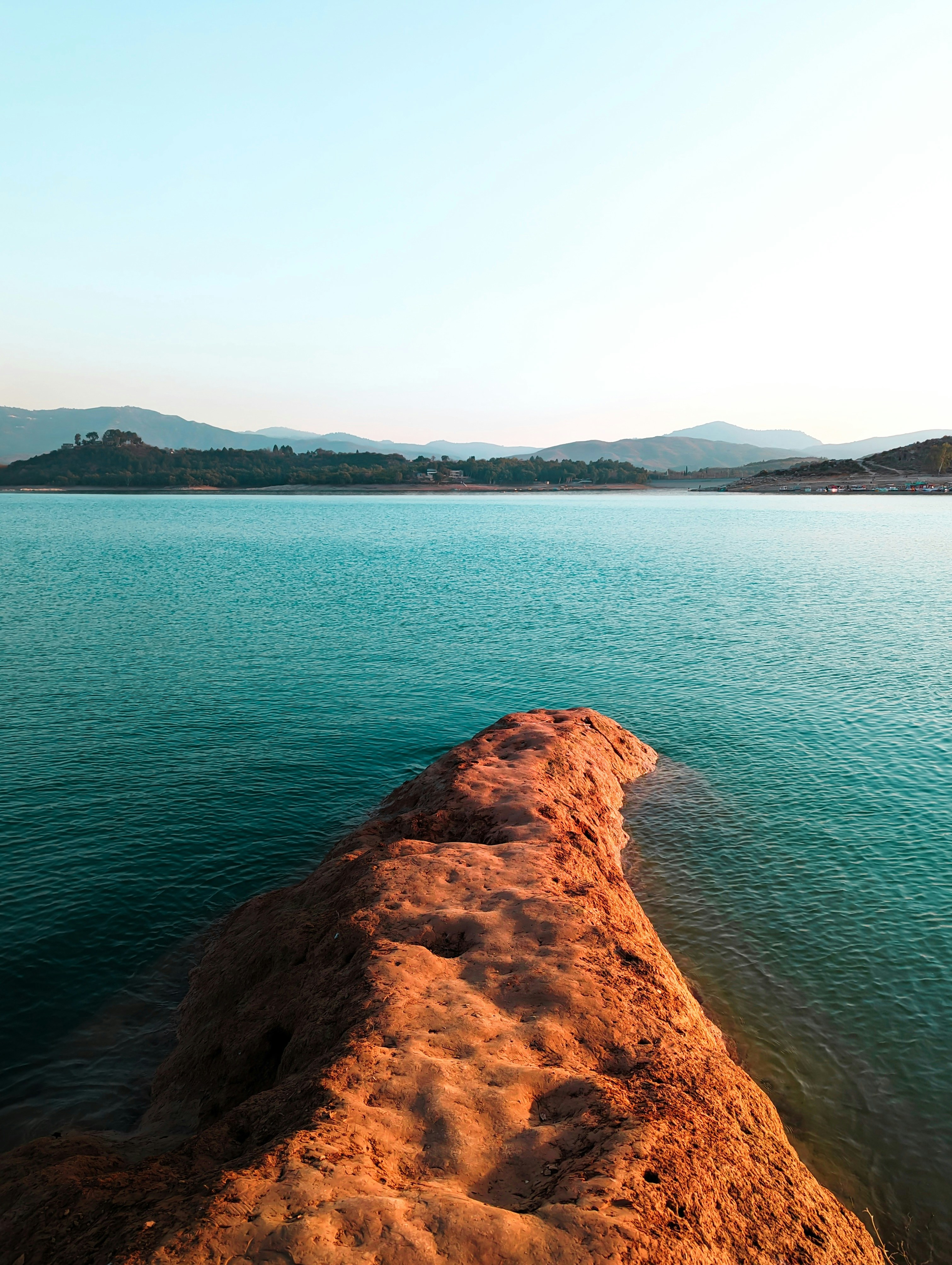 Rust-Red Promontory Extending Into Serene Turquoise Bay