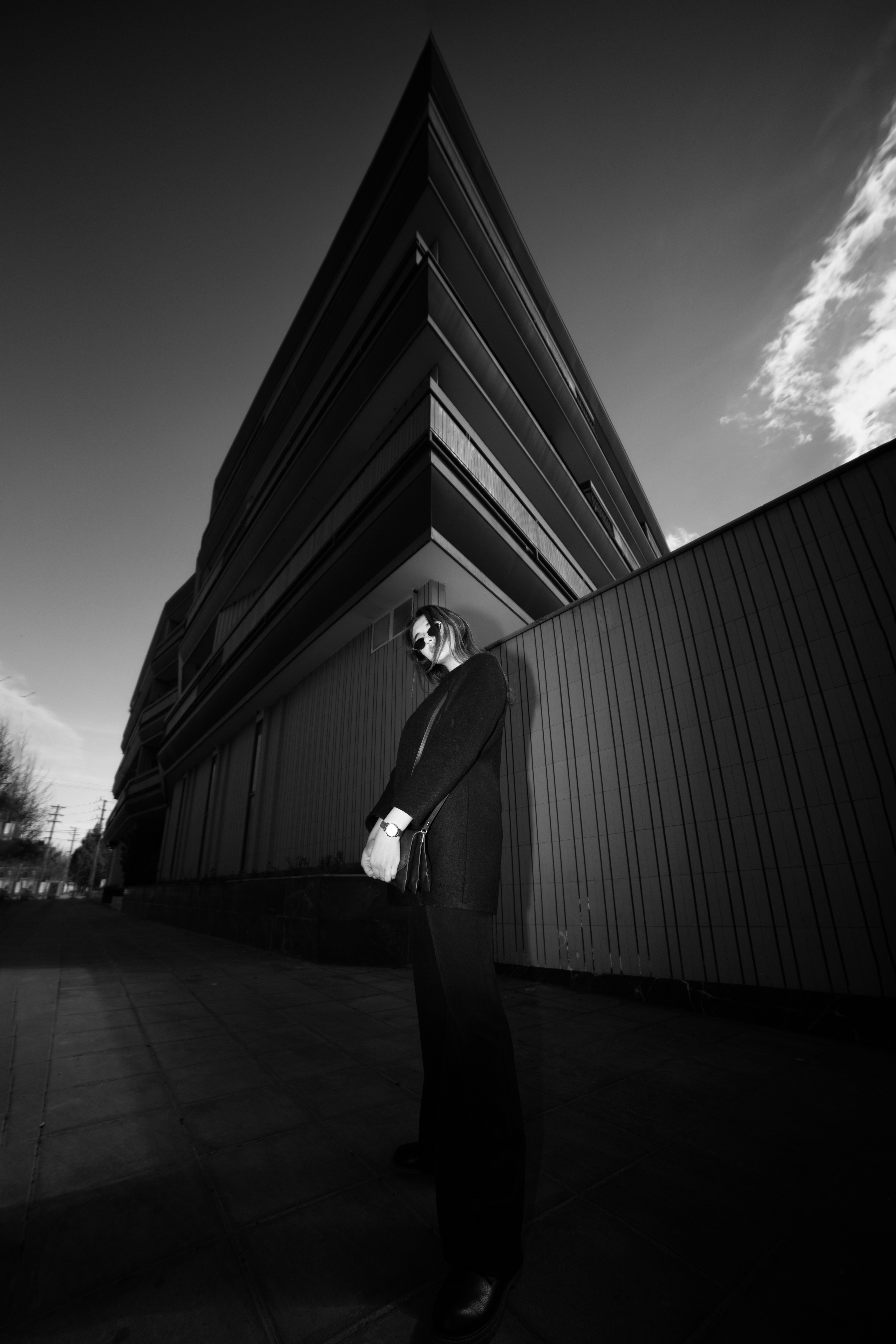 a man in a suit standing in front of a building