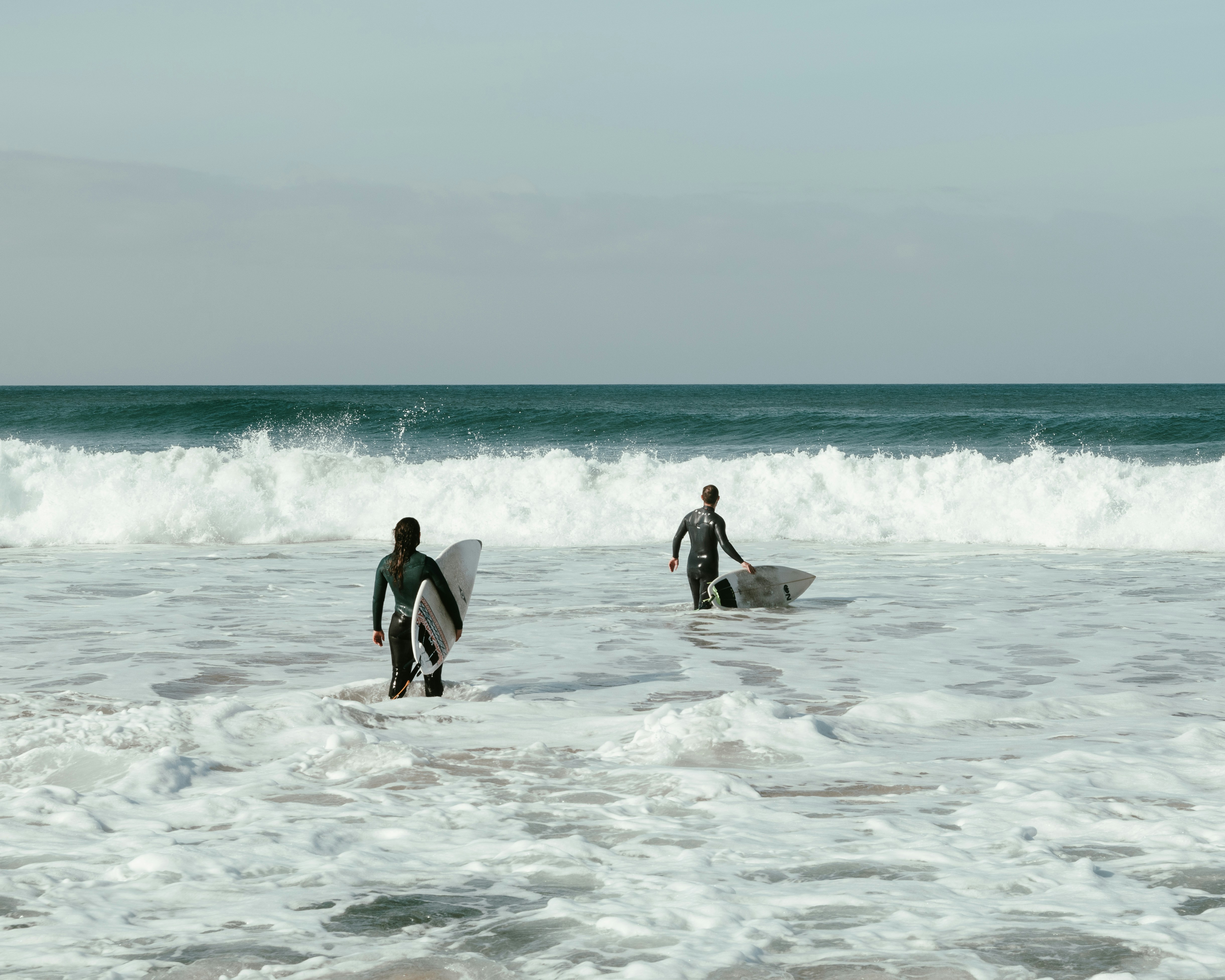 Two Surfers at the Break: White Foam and Blue Horizon