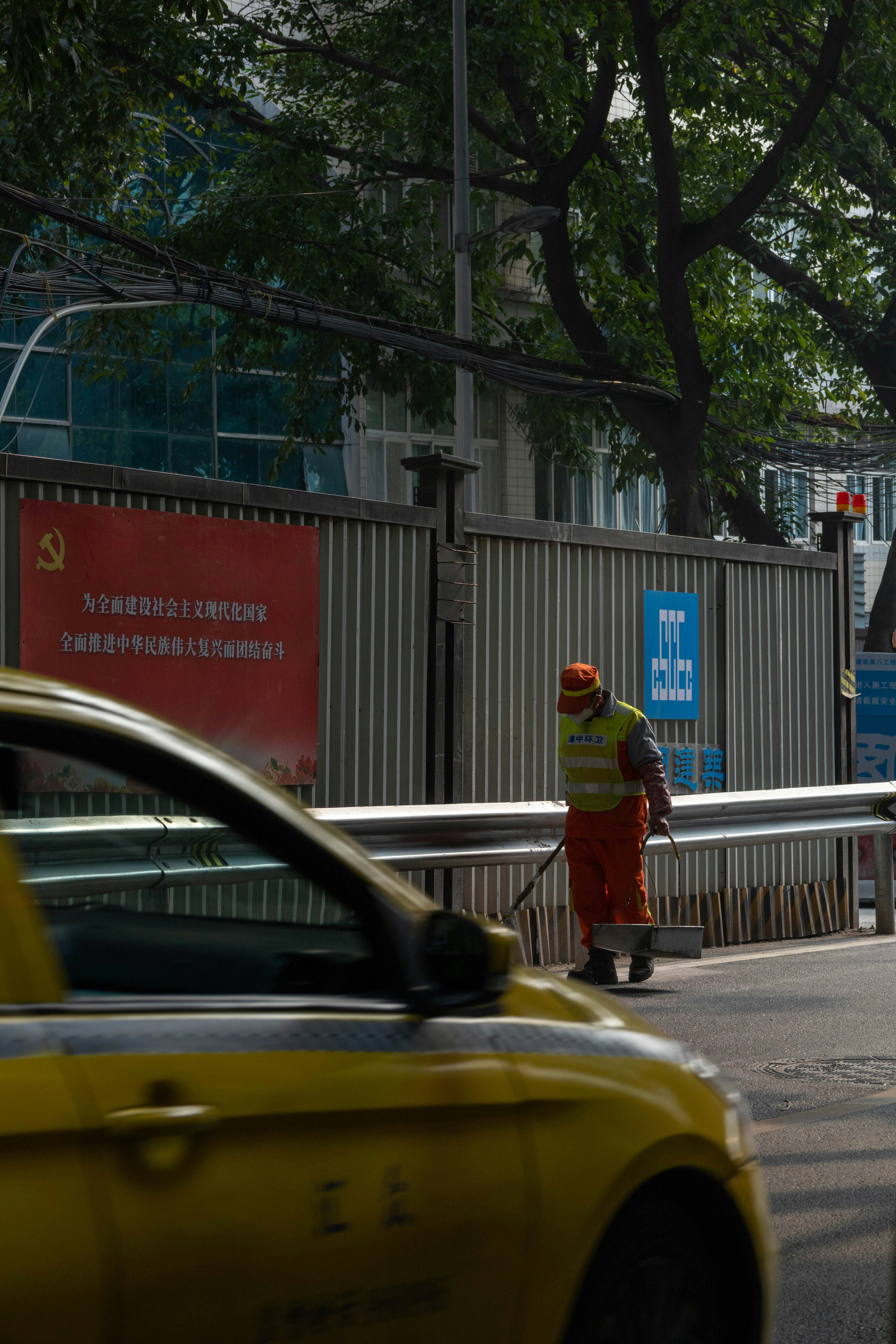 Barrier Ranger: A Streetwork Moment Framed by a Moving Taxi
