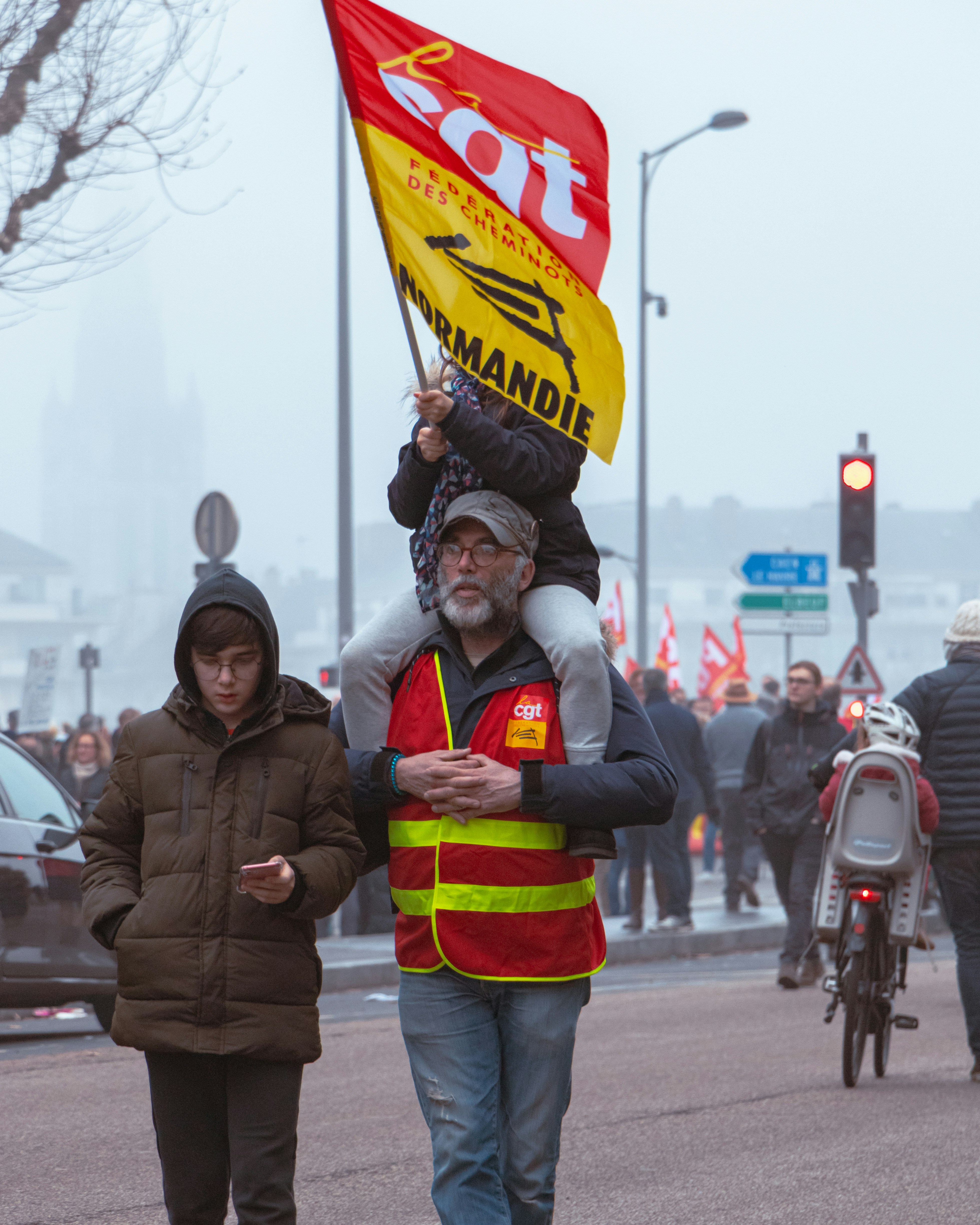 Flags of Solidarity: A Man and Child Rally Amid a Distant Cityscape