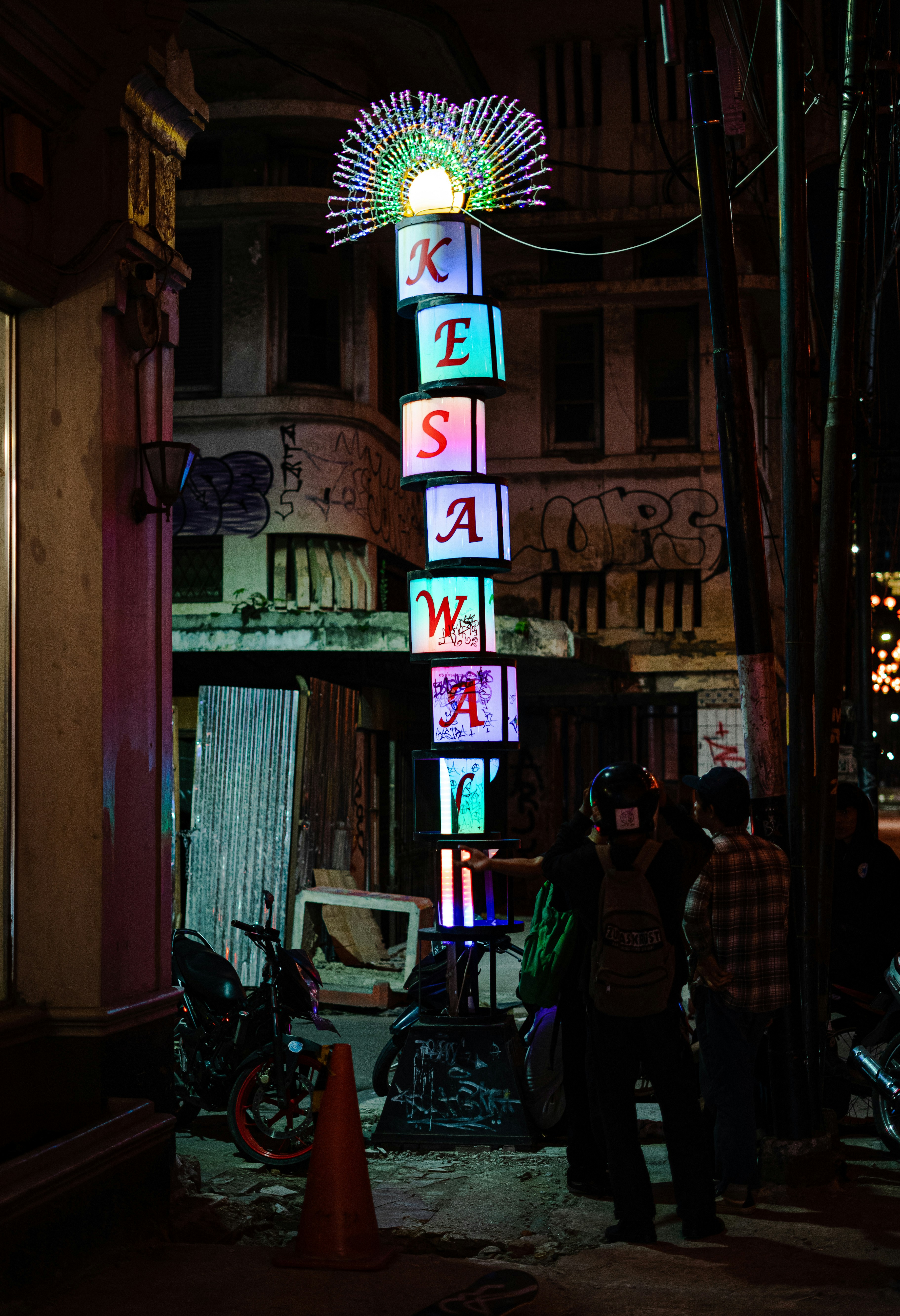 Tower of Light: Neon Block Sign Crowned by a Circular Crest in a Night Alley
