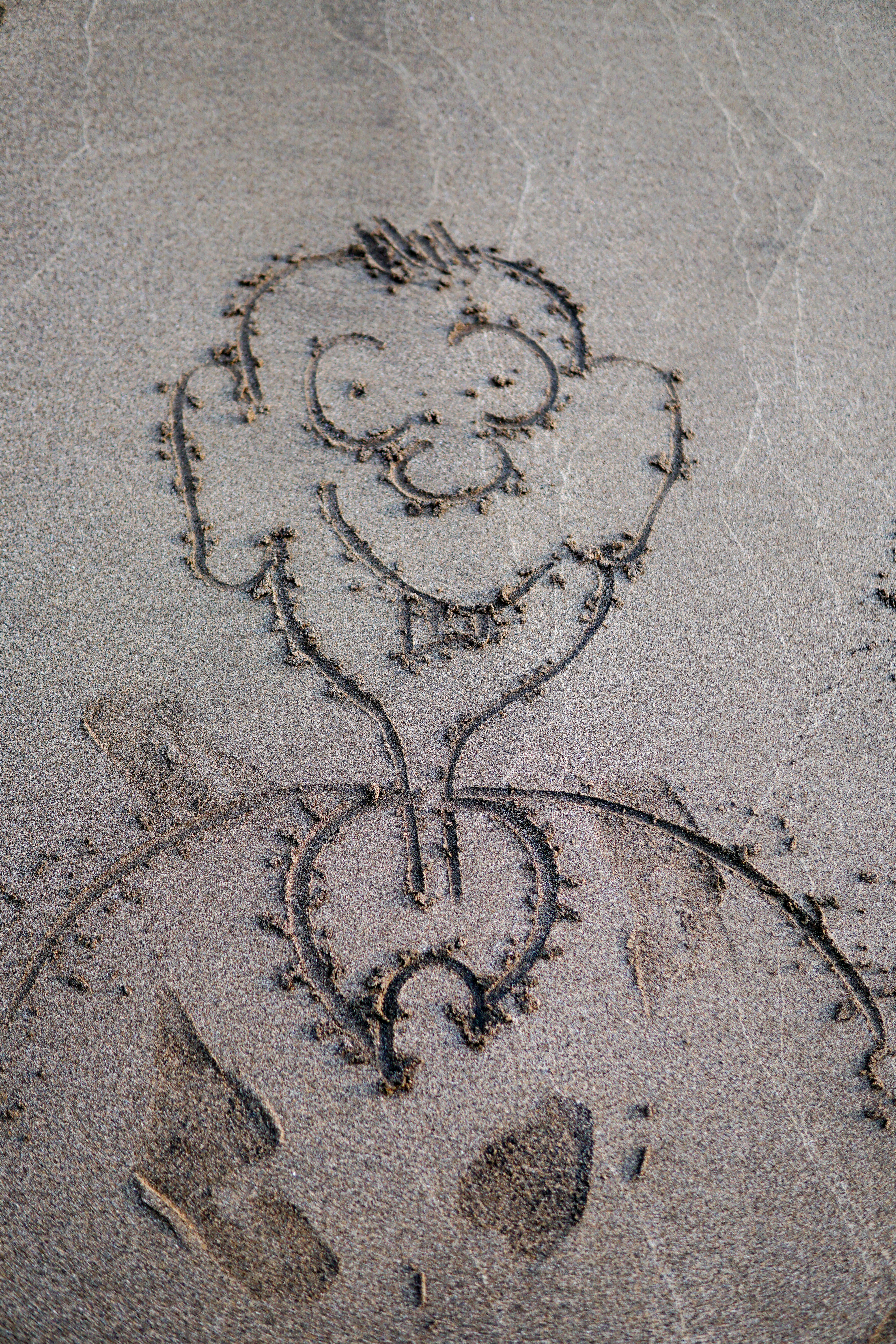 a child's face is drawn in the sand
