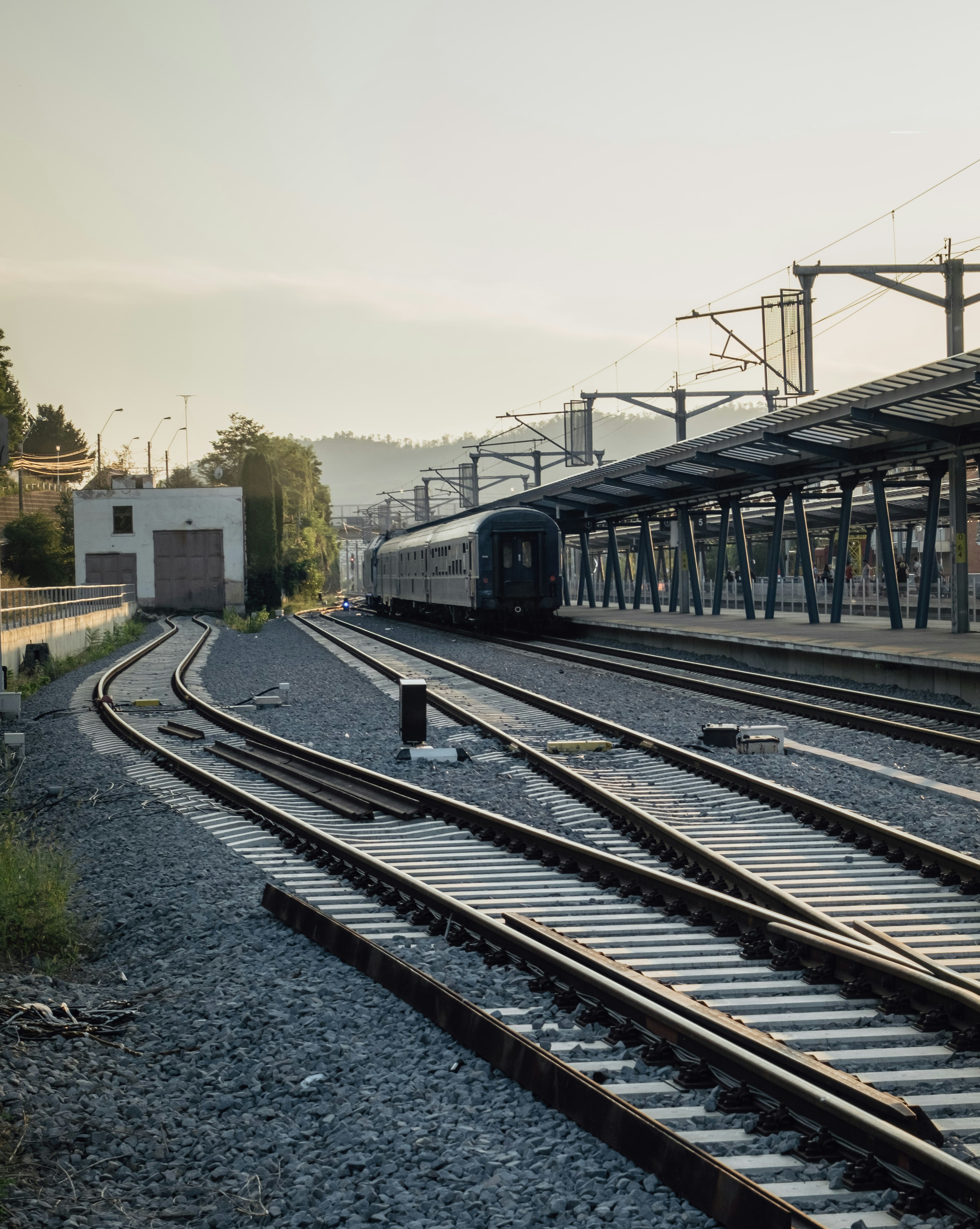A train traveling down train tracks next to a train station photo ...