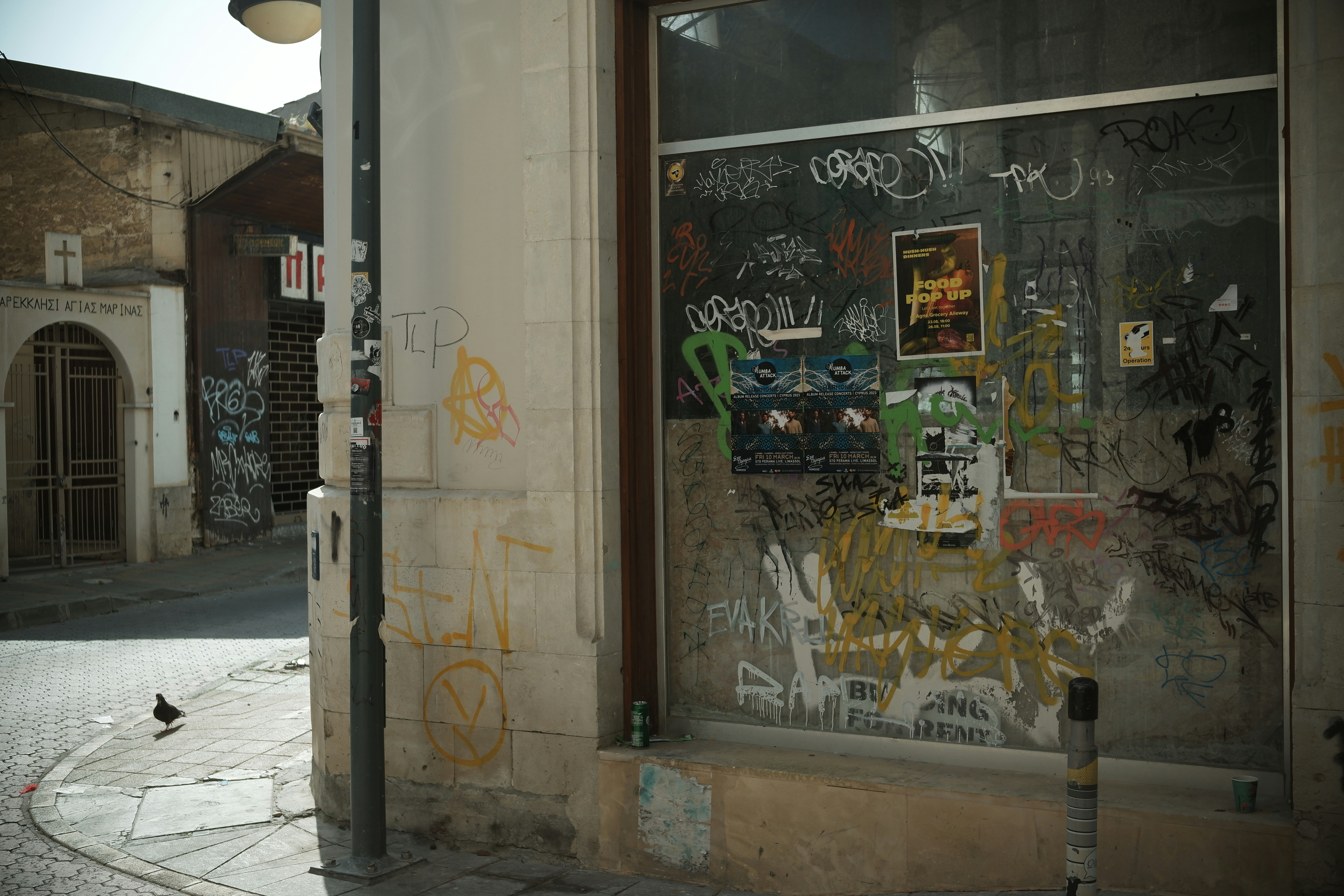 a street corner with a store front covered in graffiti