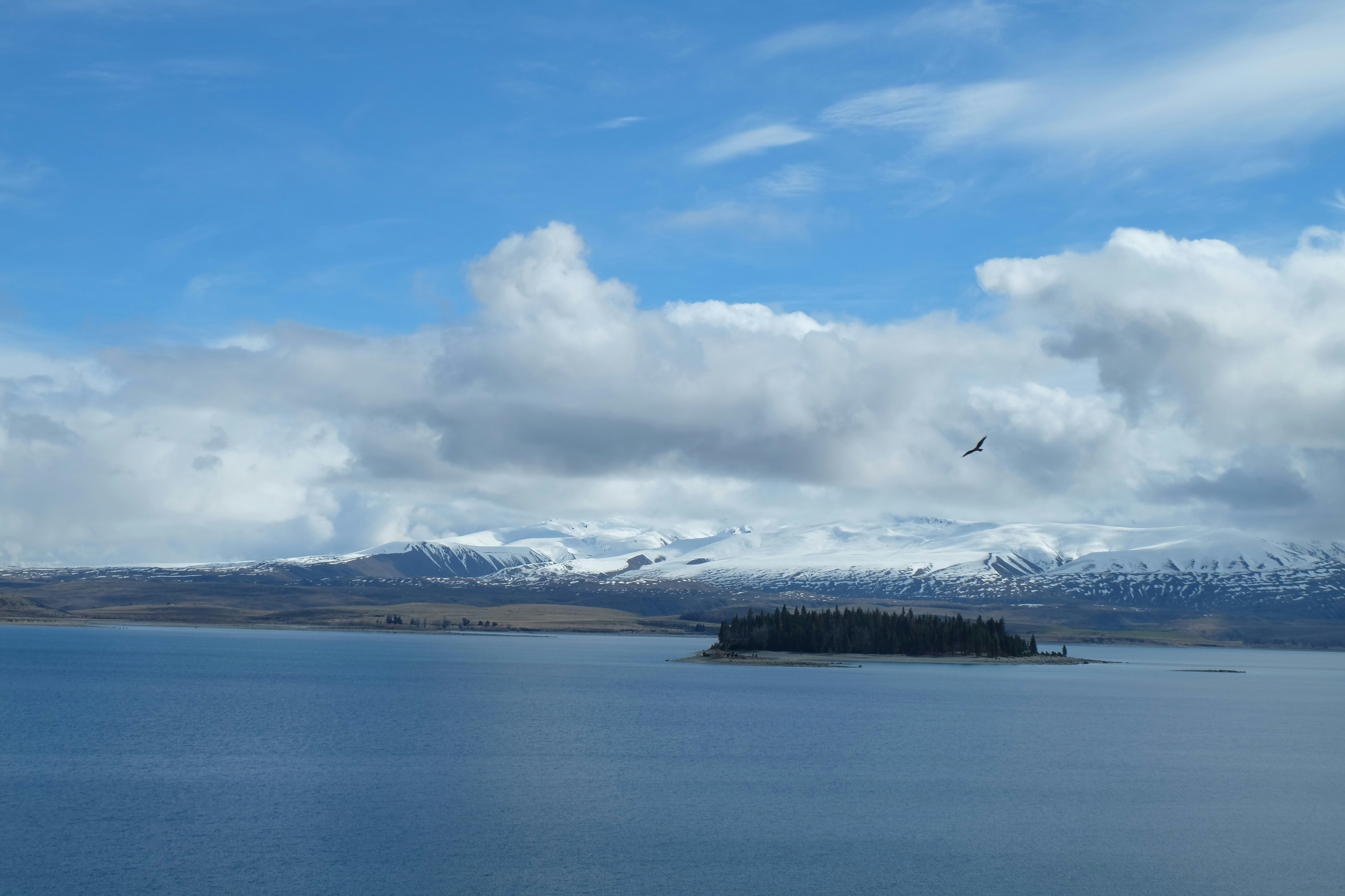 A large body of water surrounded by snow covered mountains photo – Free ...