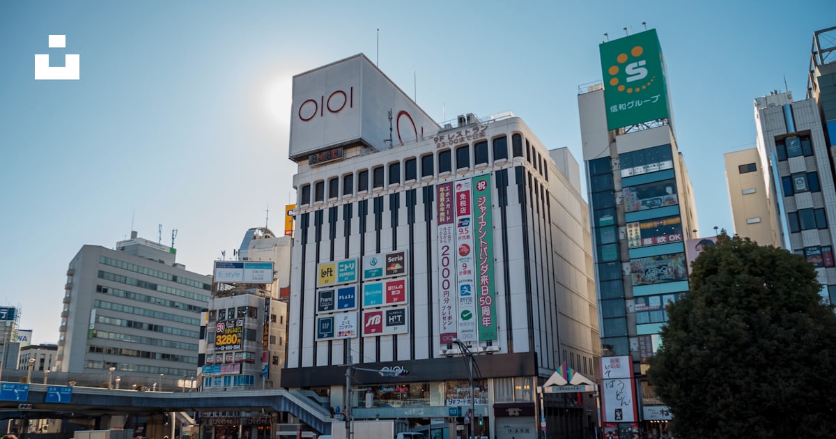 많은 사람들이 걸어 다니는 큰 건물 사진 Unsplash의 무료 도시 이미지