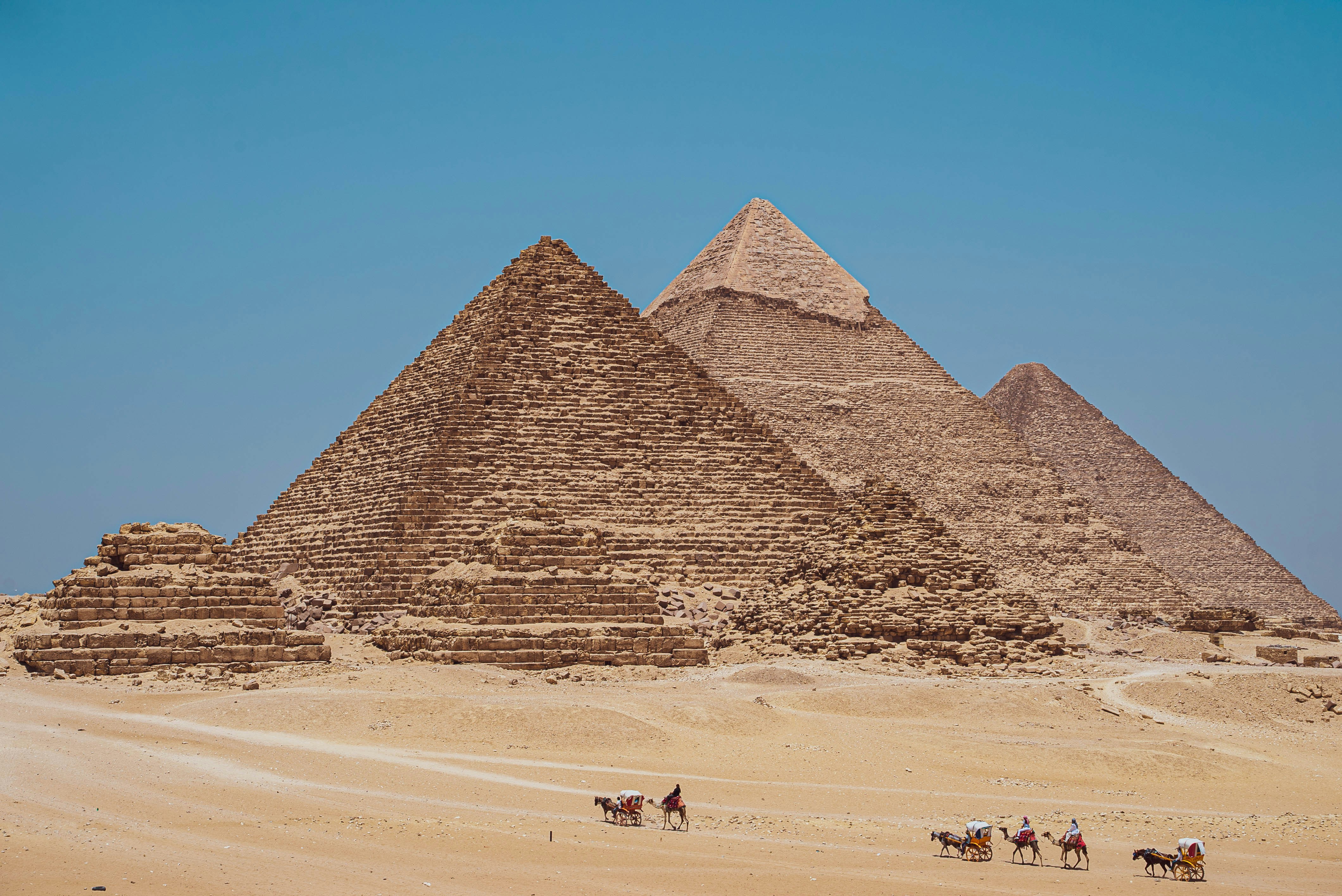 A group of people riding horses next to the pyramids of giza photo ...