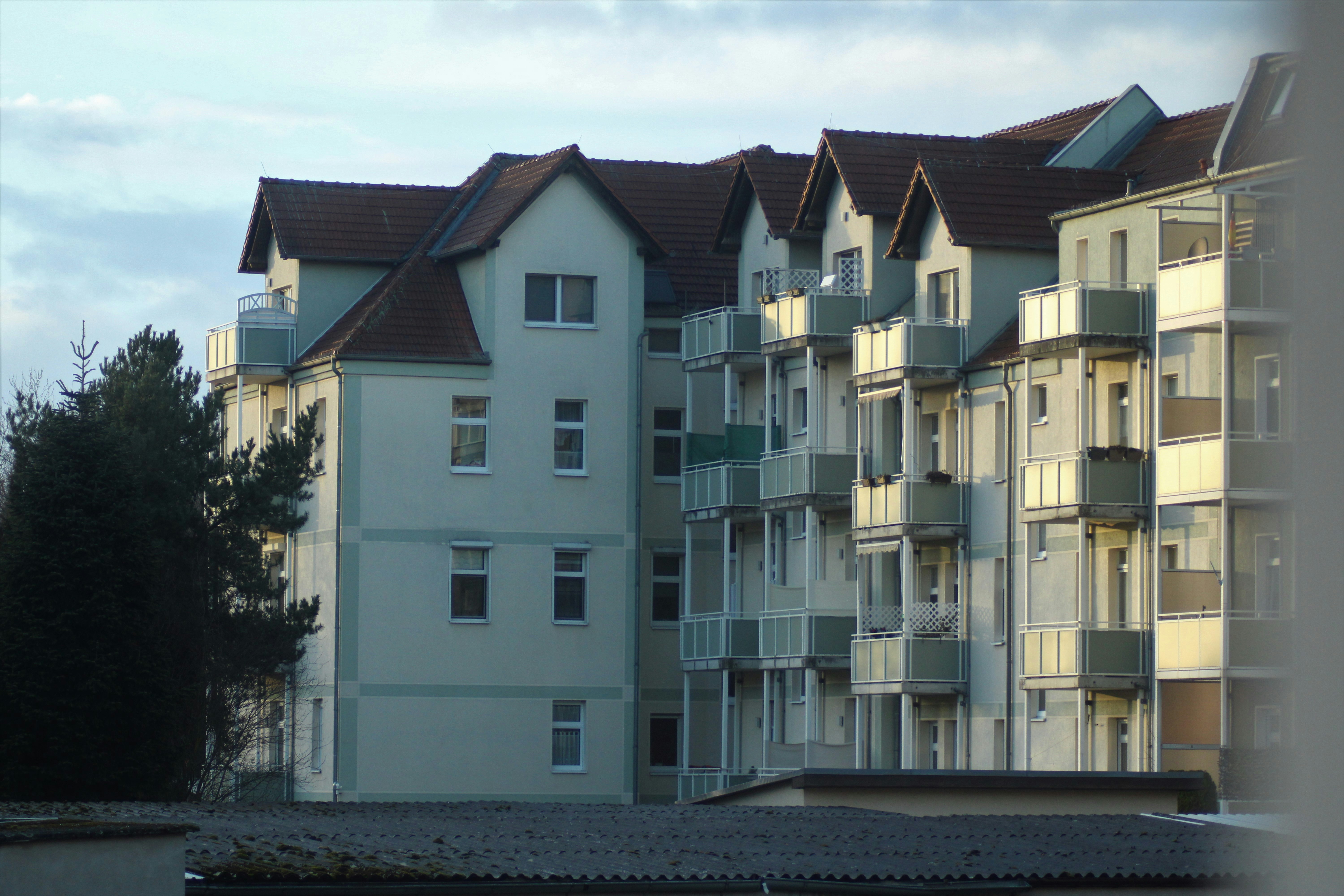 A row of apartment buildings next to a body of water photo – Free ...