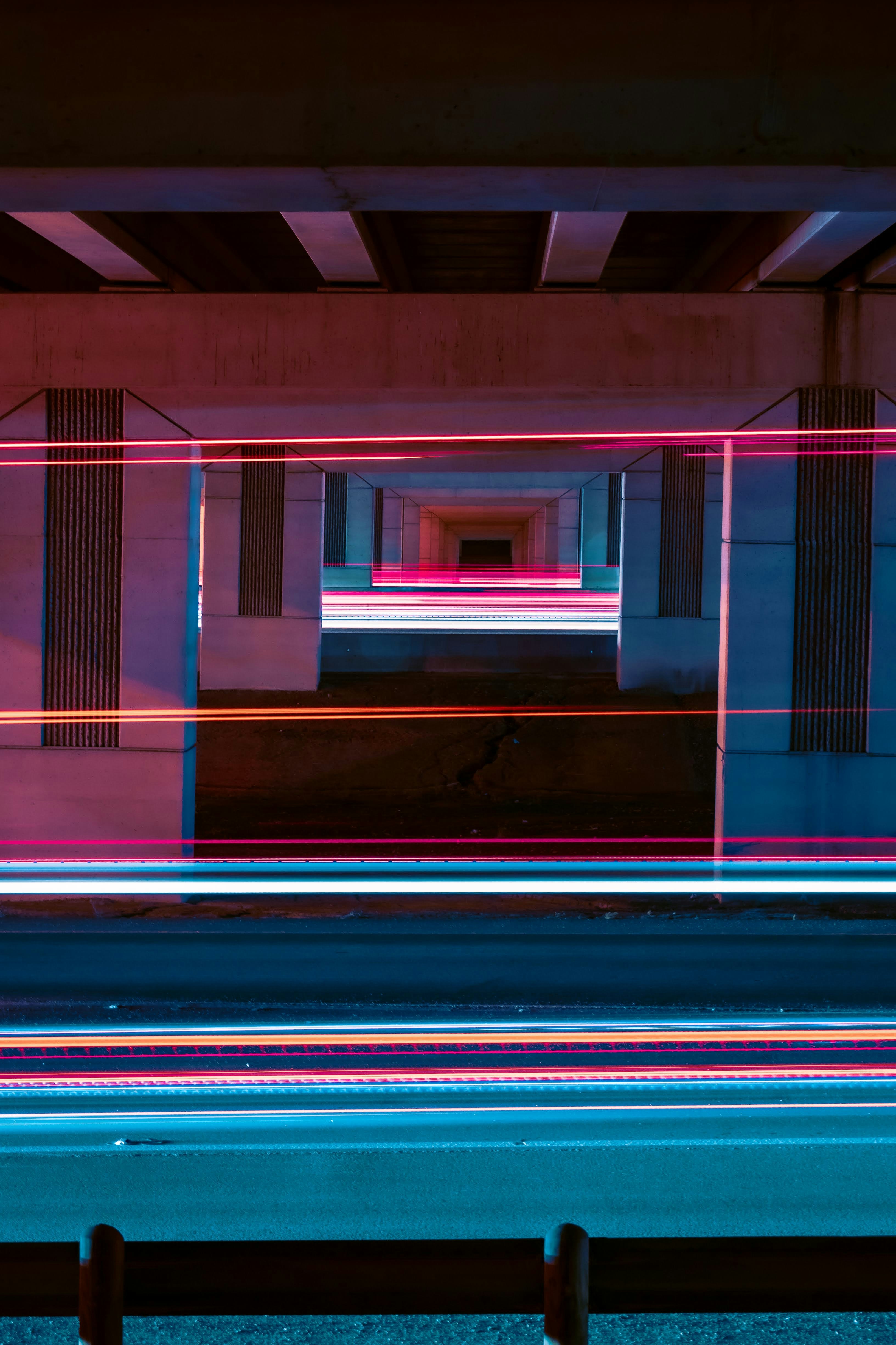 long exposure sot of cars passing under a bridge. very vaporwave like