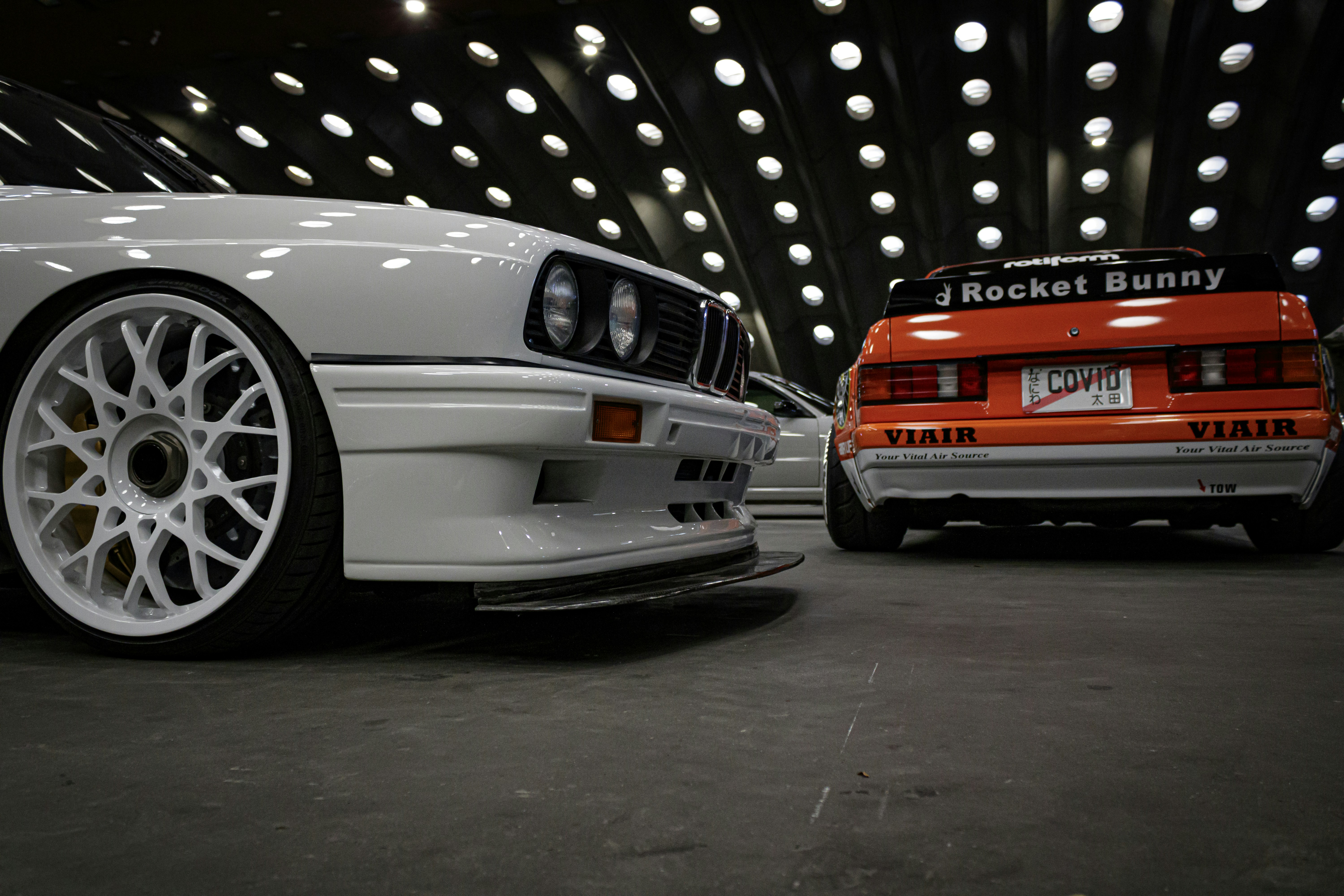 Two cars parked next to each other in a garage photo – Free ...