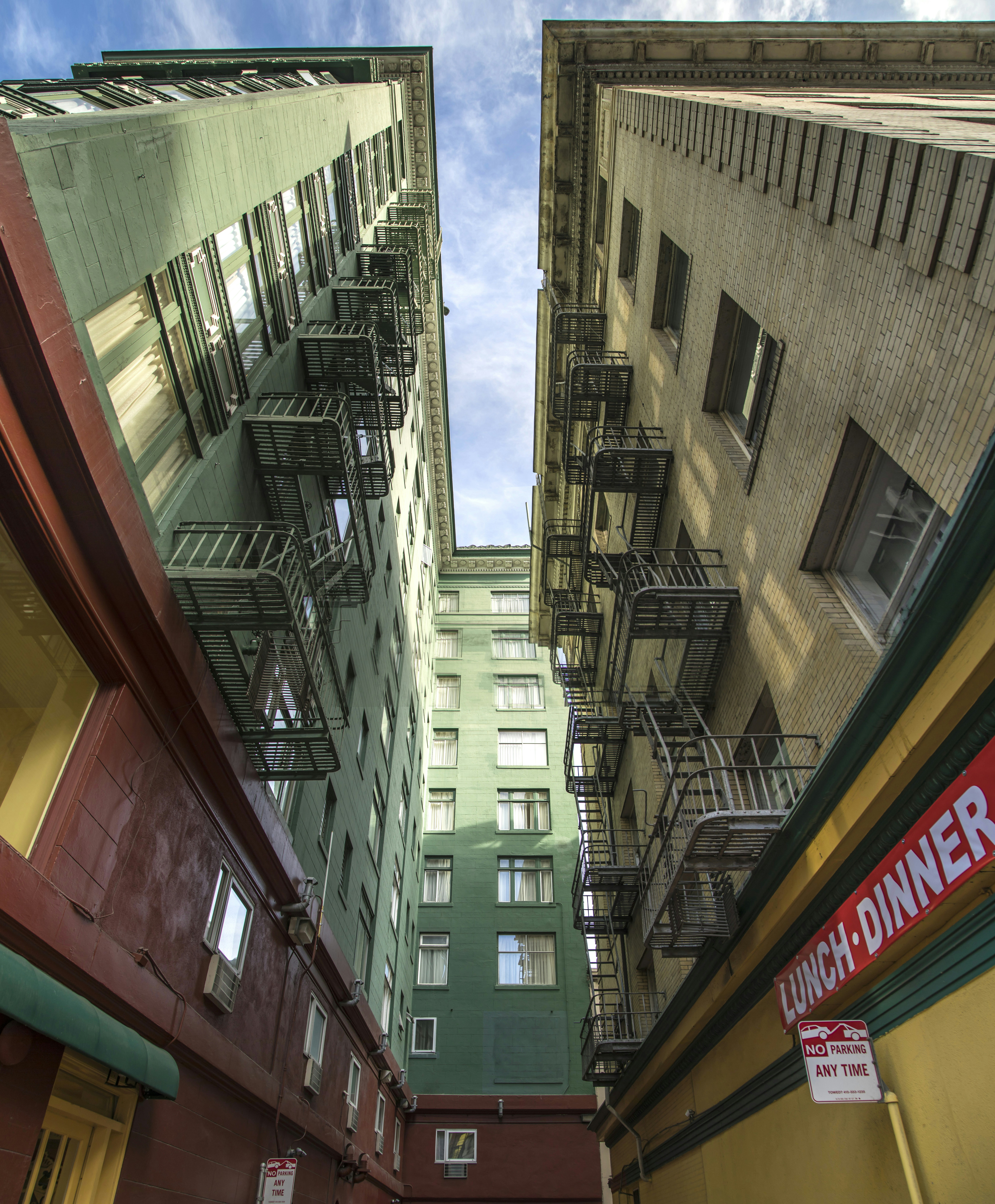 A narrow alley way between two tall buildings photo – Free City Image ...