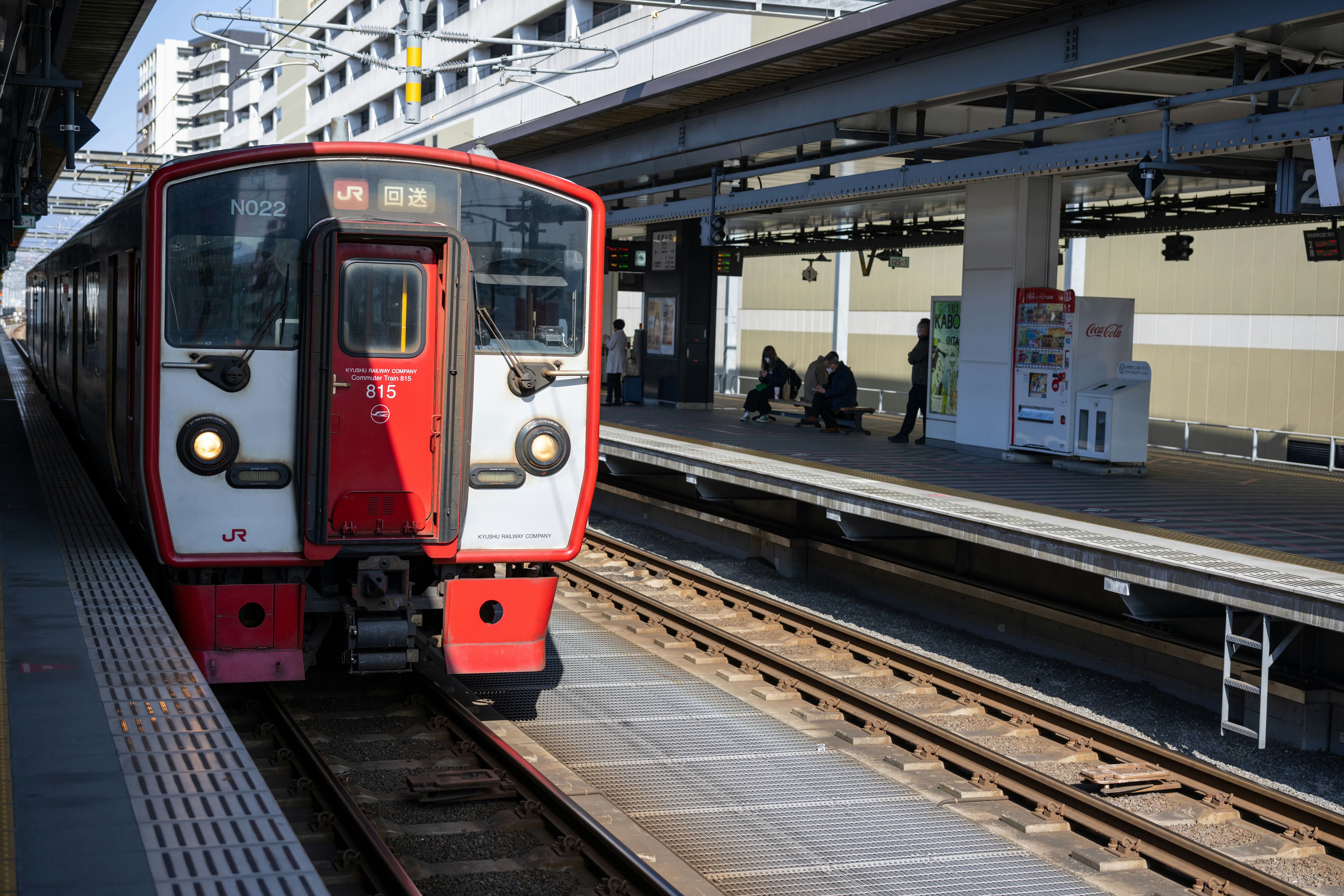 Foto zum Thema Ein rot-weißer Zug fährt in einen Bahnhof ein ...