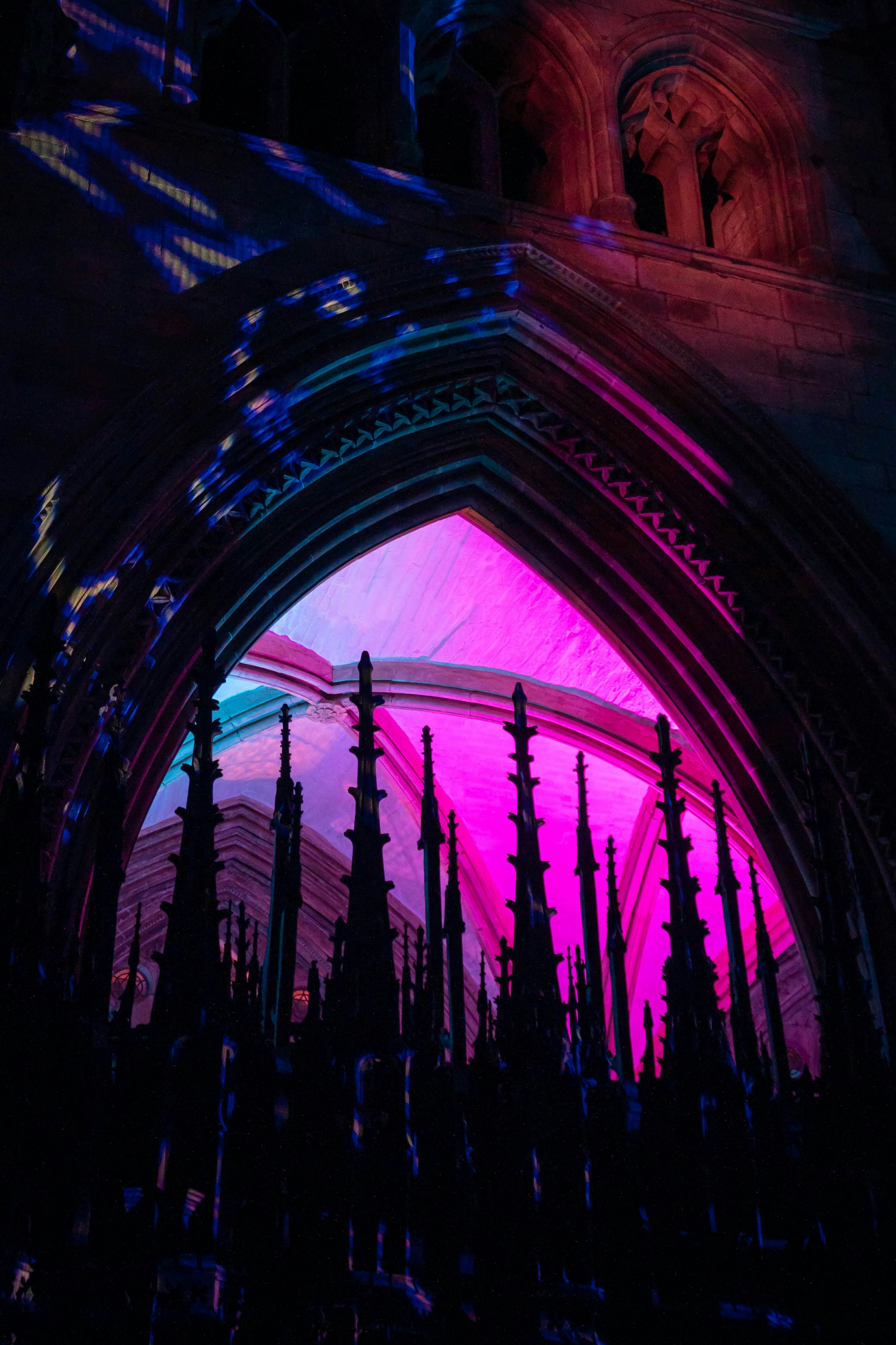 A cathedral with a pink and blue light in the background photo – Free ...