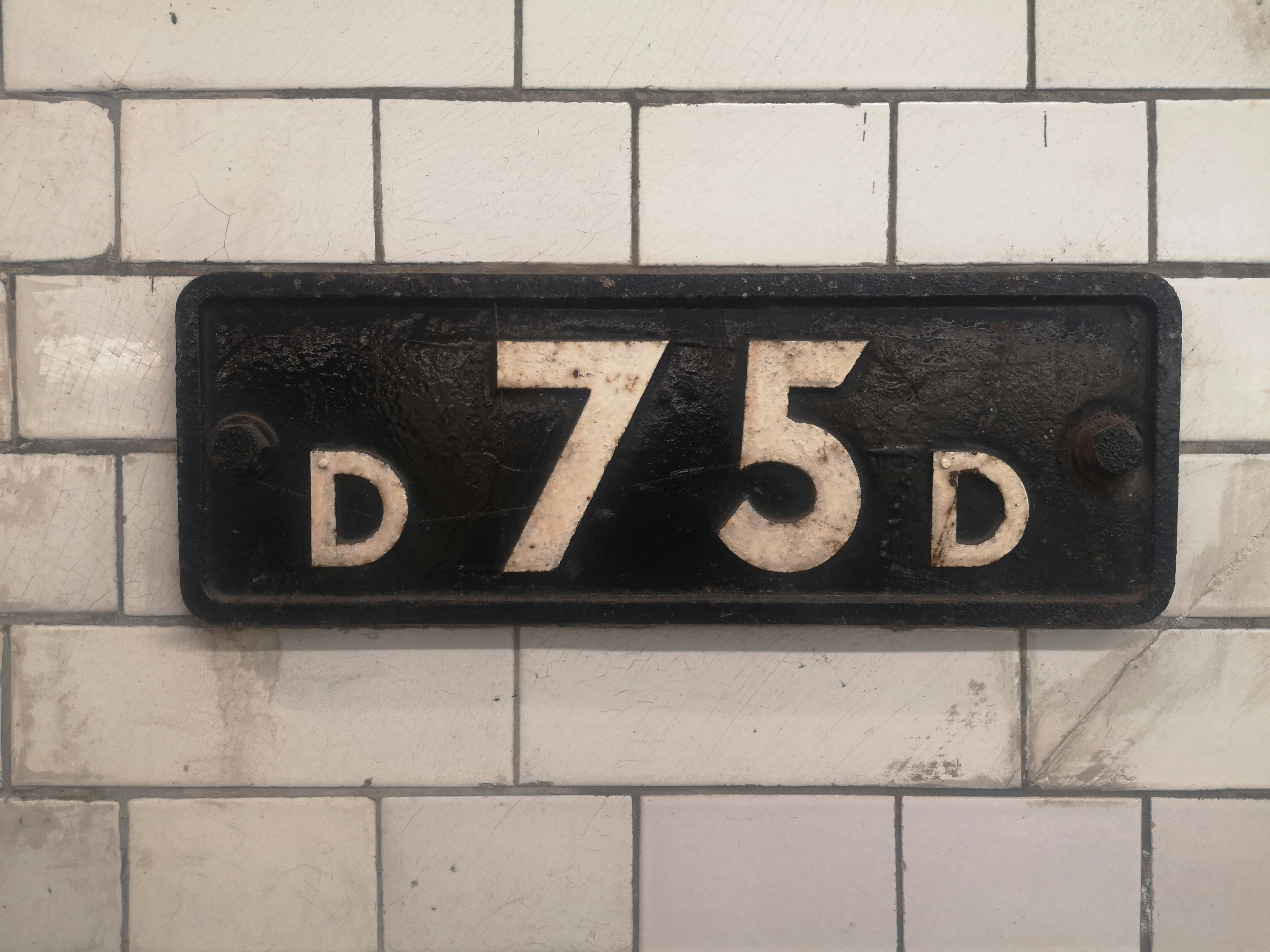 A black and white sign on a white brick wall photo – Free Turnham green ...