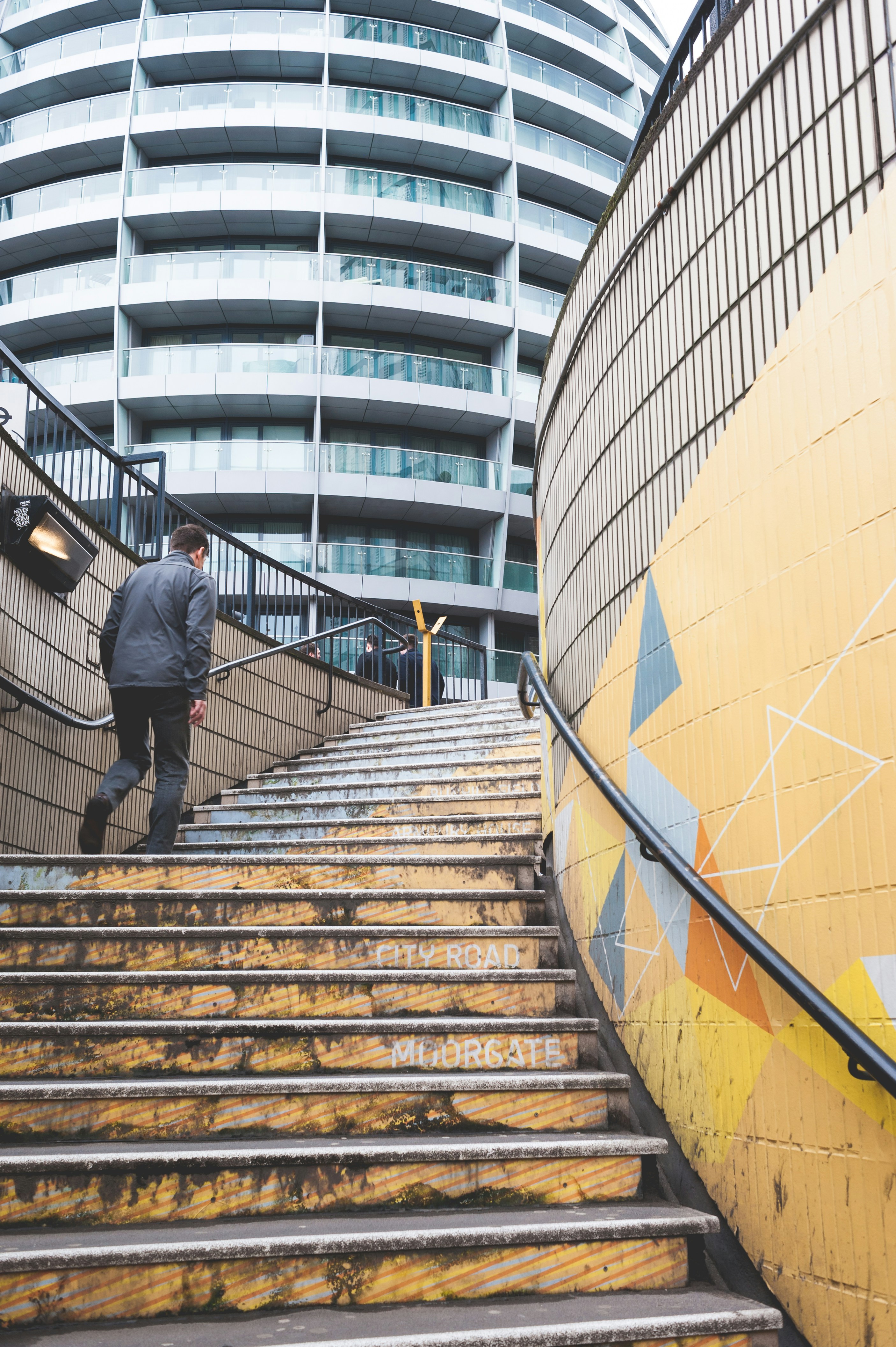 A man walking up some stairs in front of a building photo – Free Old ...