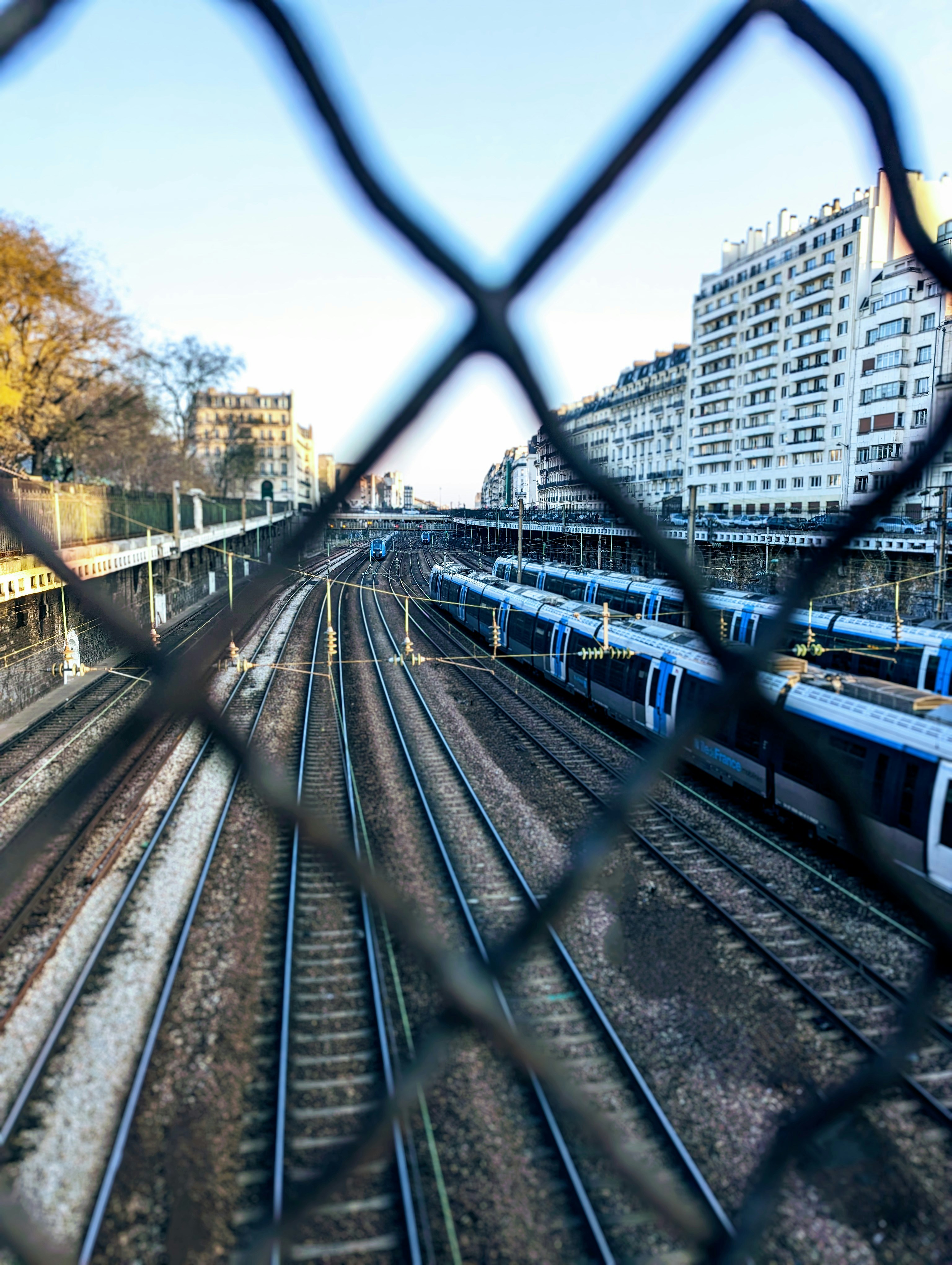 A view of a train yard through a chain link fence photo – Free Paris ...