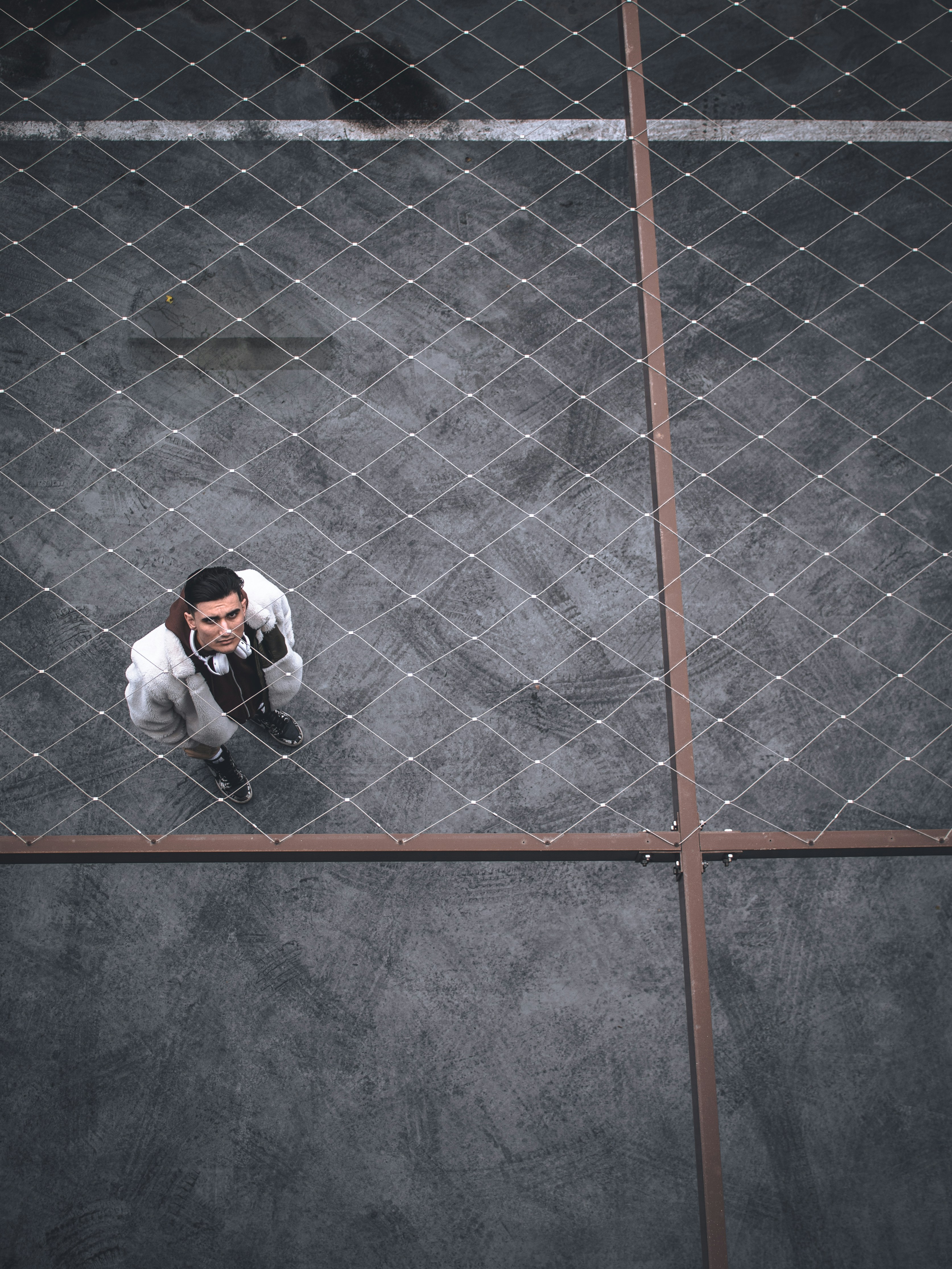 Diamond Grid Overhead: A Solitary Figure Framed by Glass and Steel