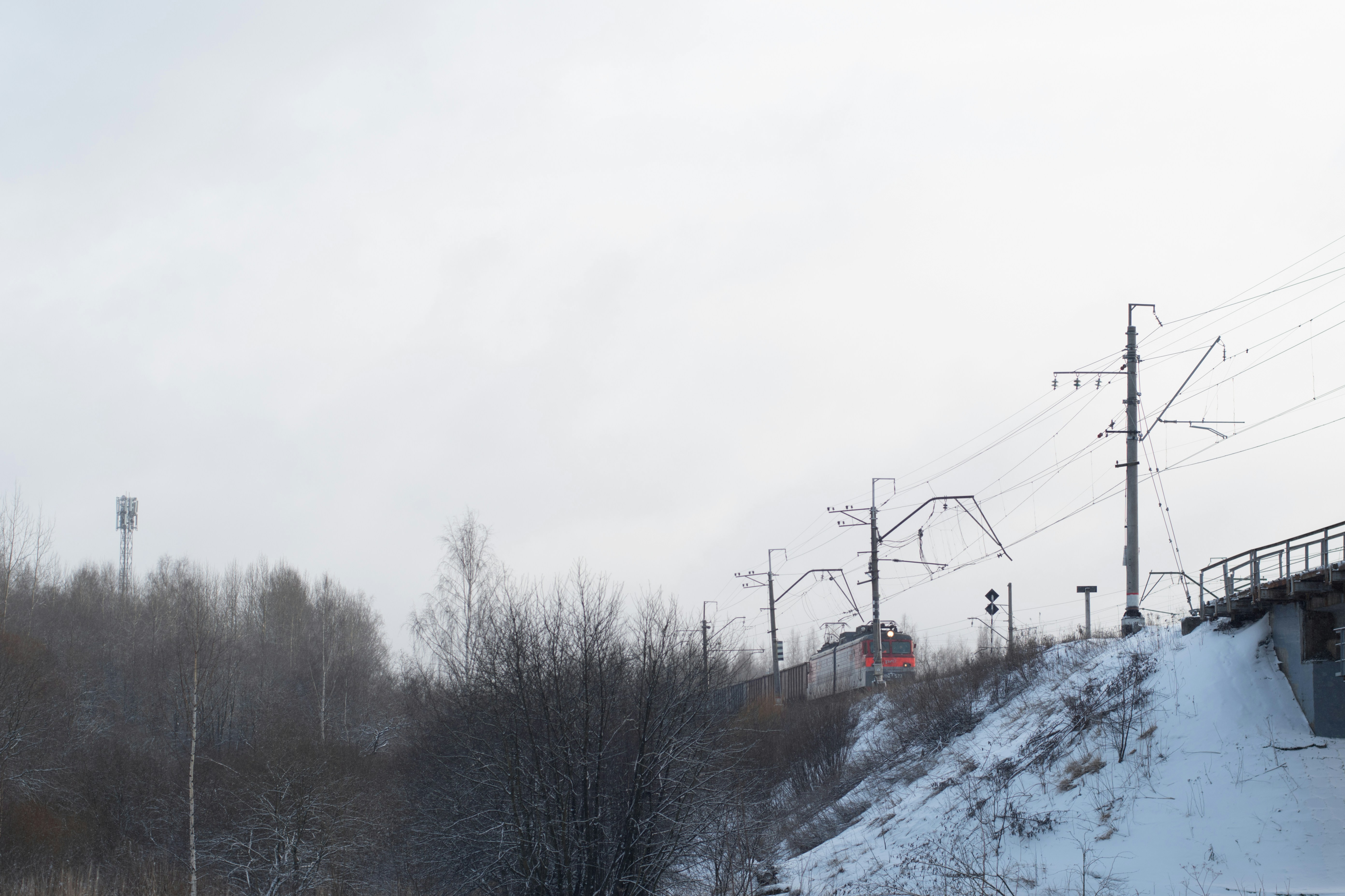 Crimson Locomotive Traces a Snow-Kissed Ridge Under an Overcast Sky