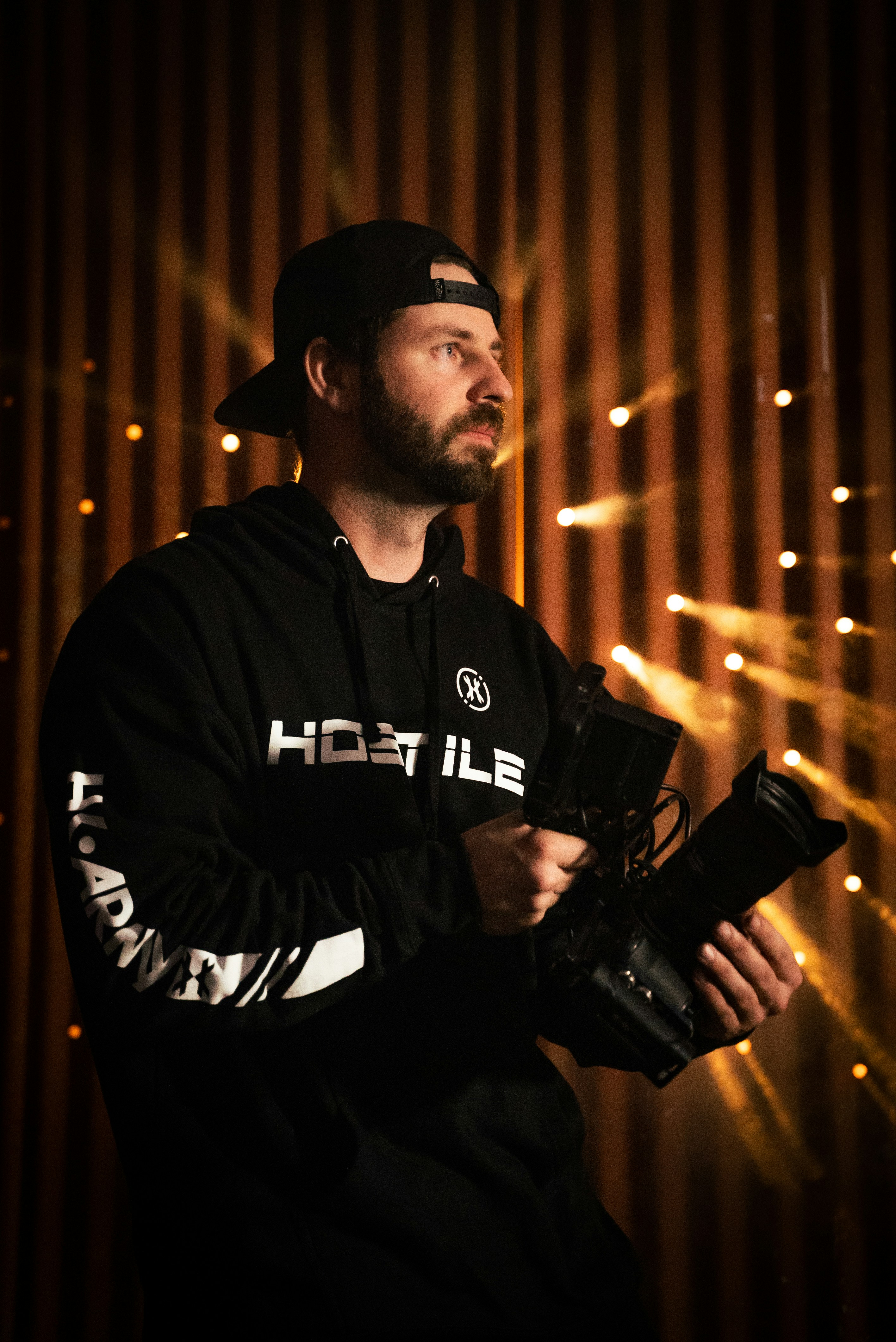 A man in a black hoodie holding a camera photo – Free Male Image on ...