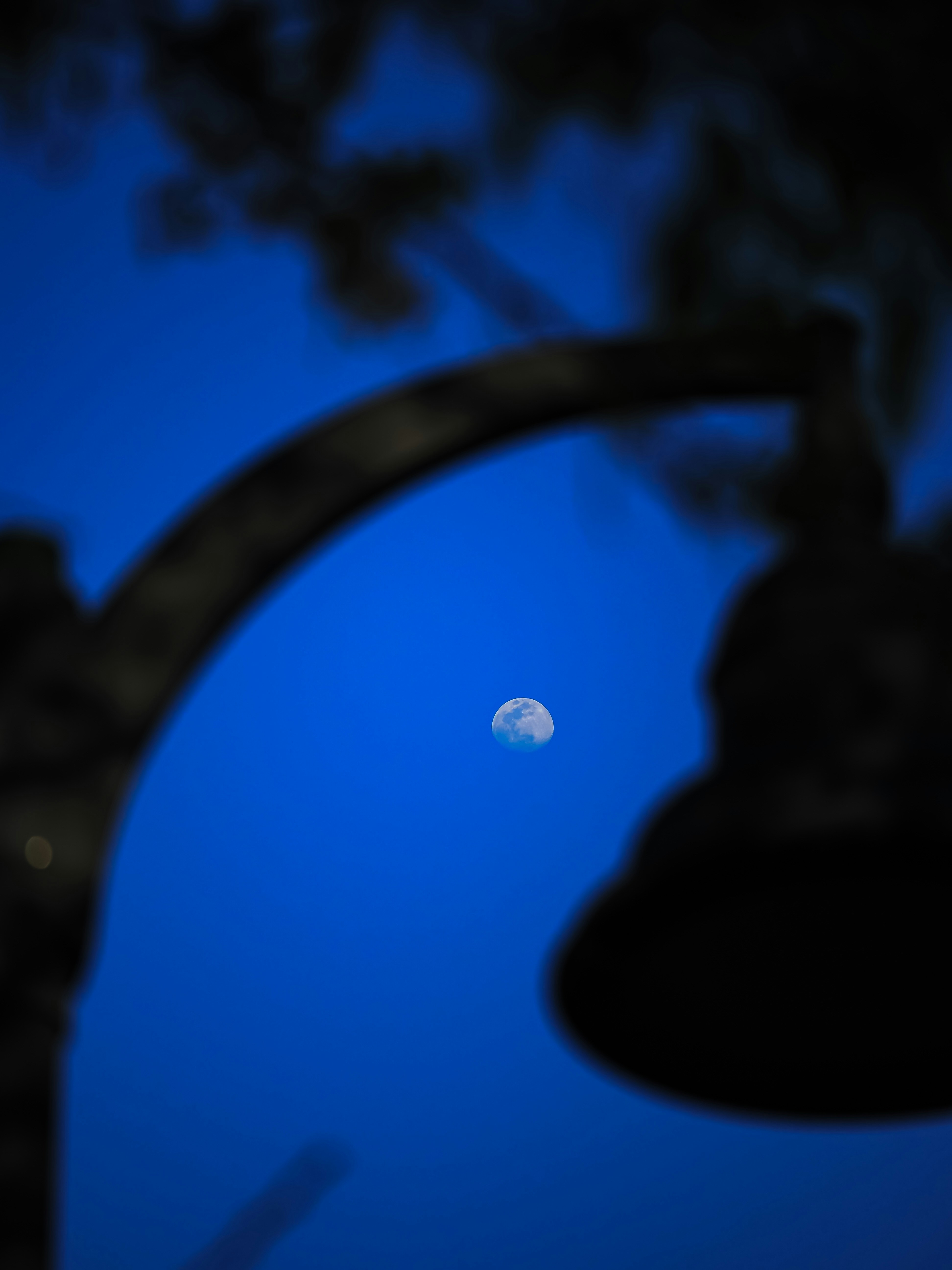Moon Through the Arch: a moody blue-hour frame of silhouettes