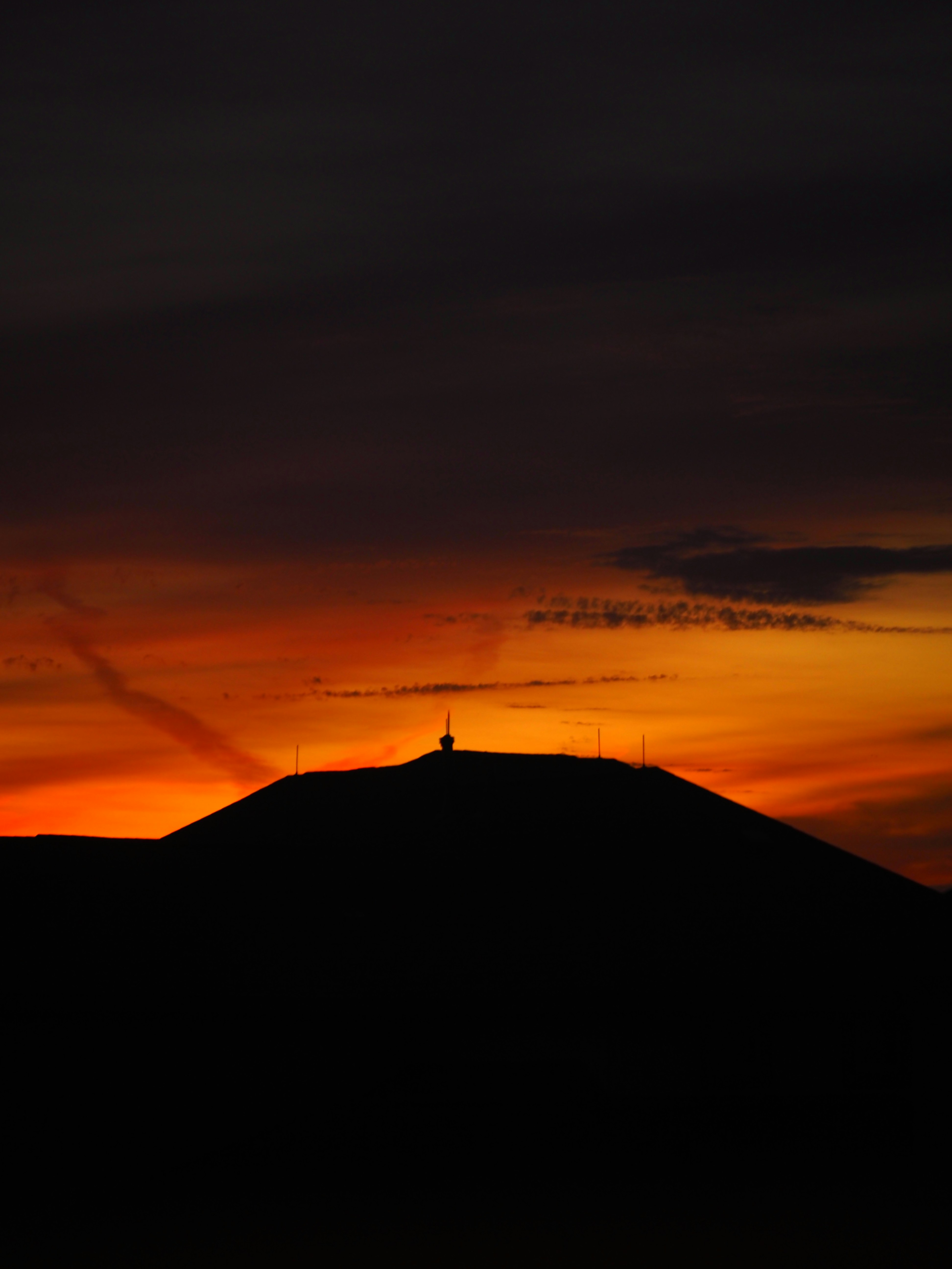 The sun is setting over a hill with a tower photo – Free Sunset Image ...