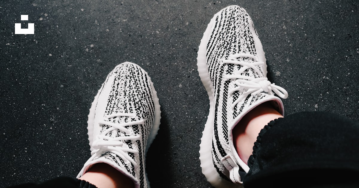 Foto Los Pies De Una Persona En Zapatillas Blancas Sobre Un Piso Negro