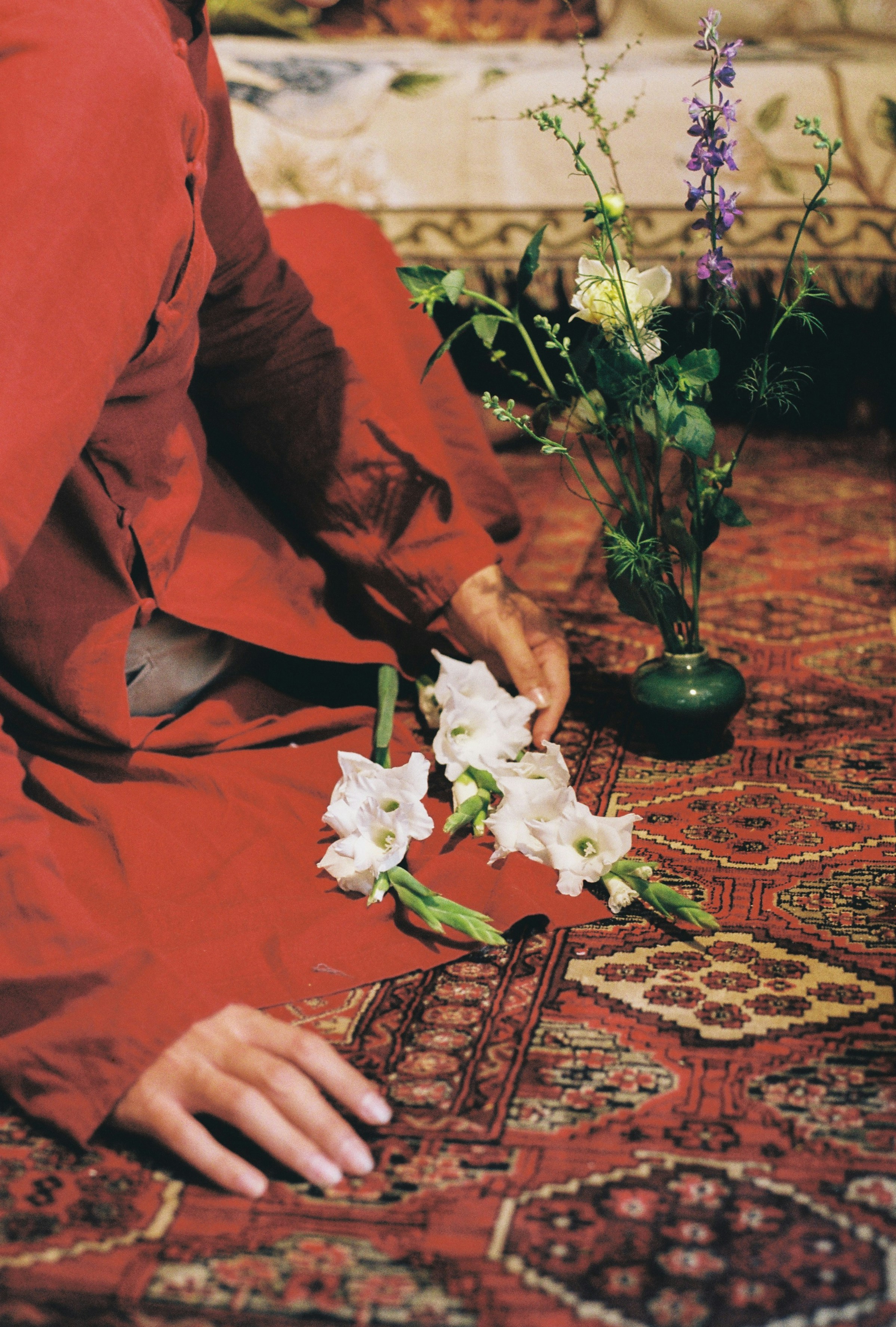 Red Garment and Floral Offerings on a Persian Rug