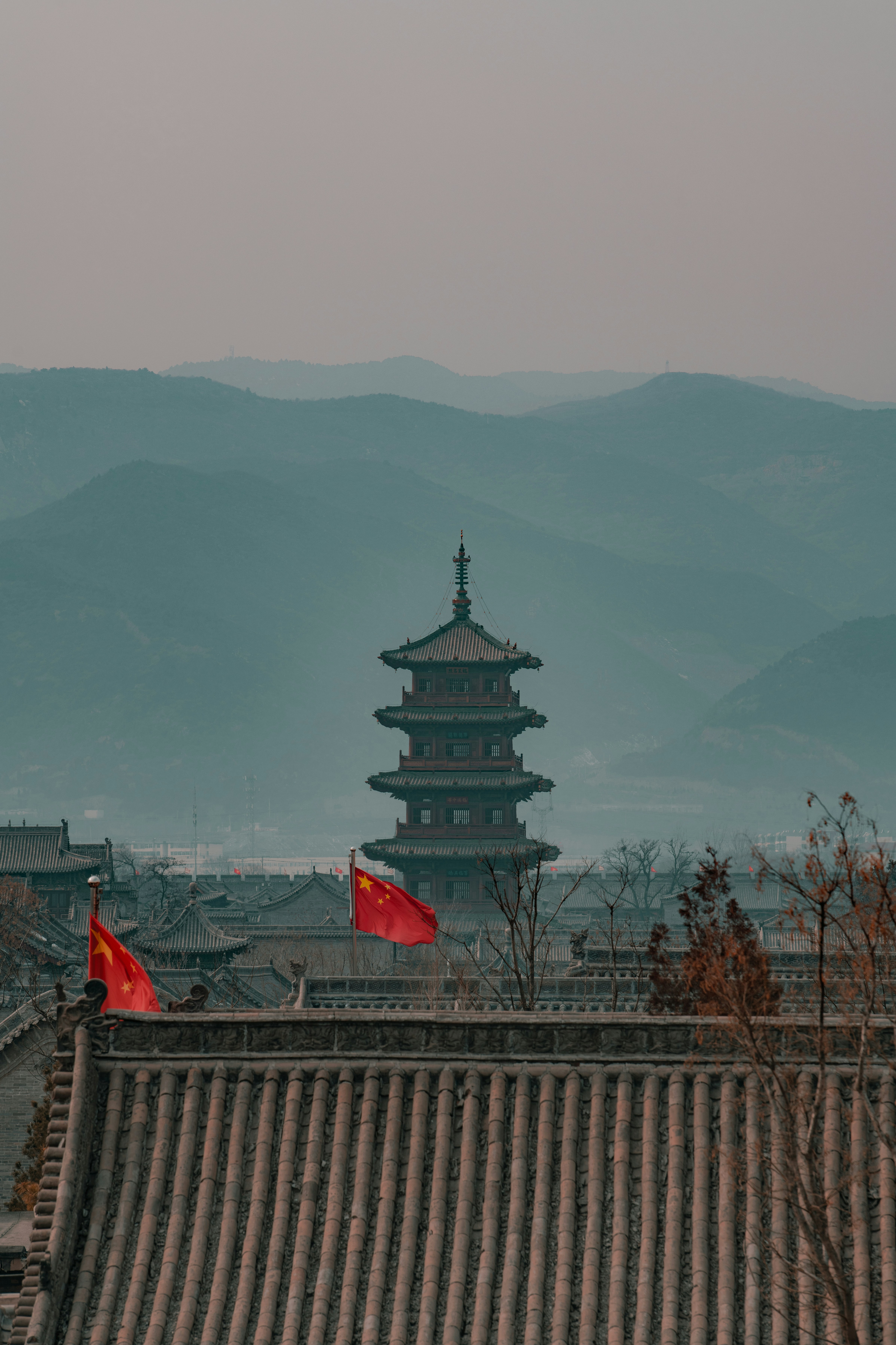 Chinese dramatic scene | a tall building with a flag on top of it