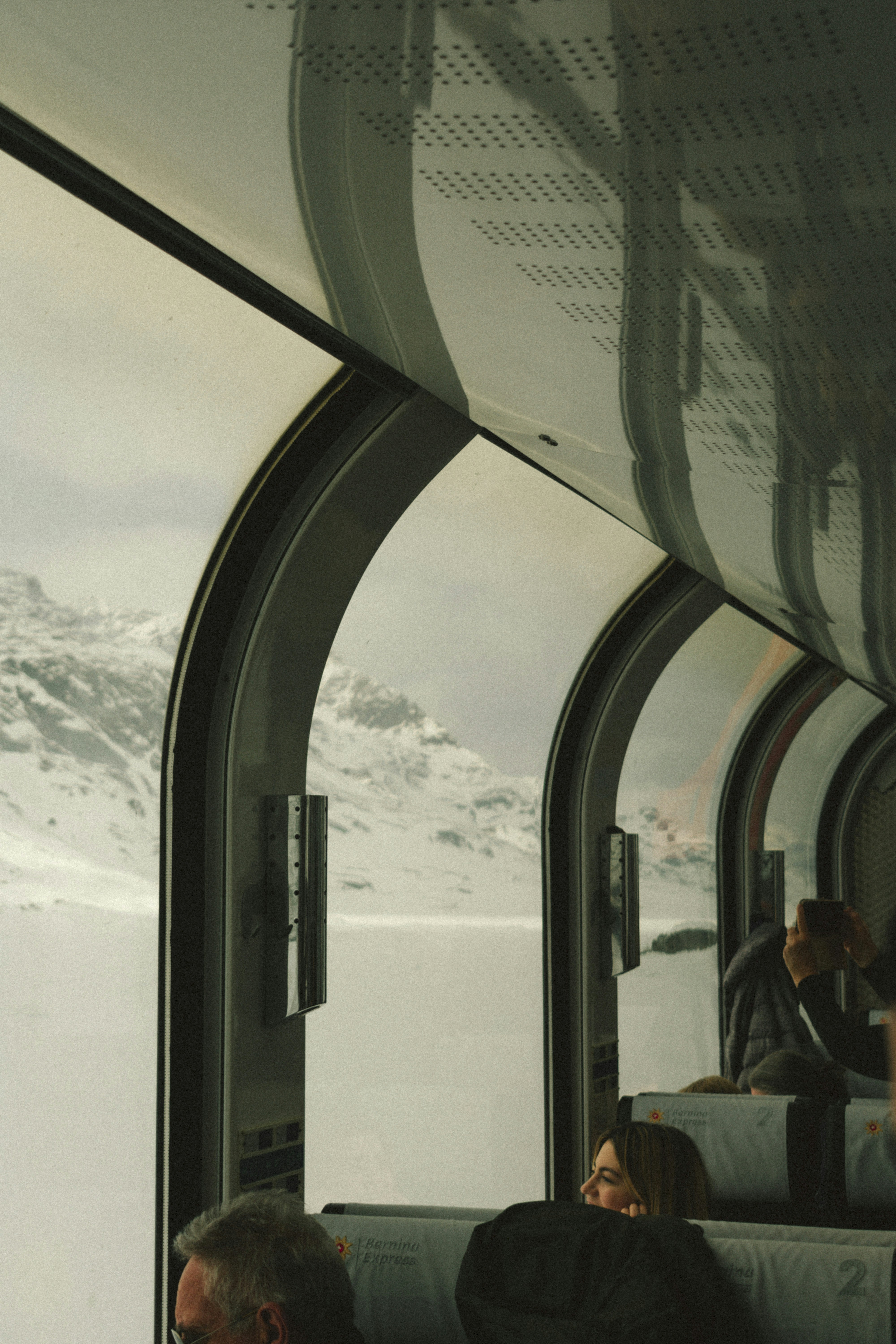 A group of people sitting on top of a train photo – Free Bernina ...