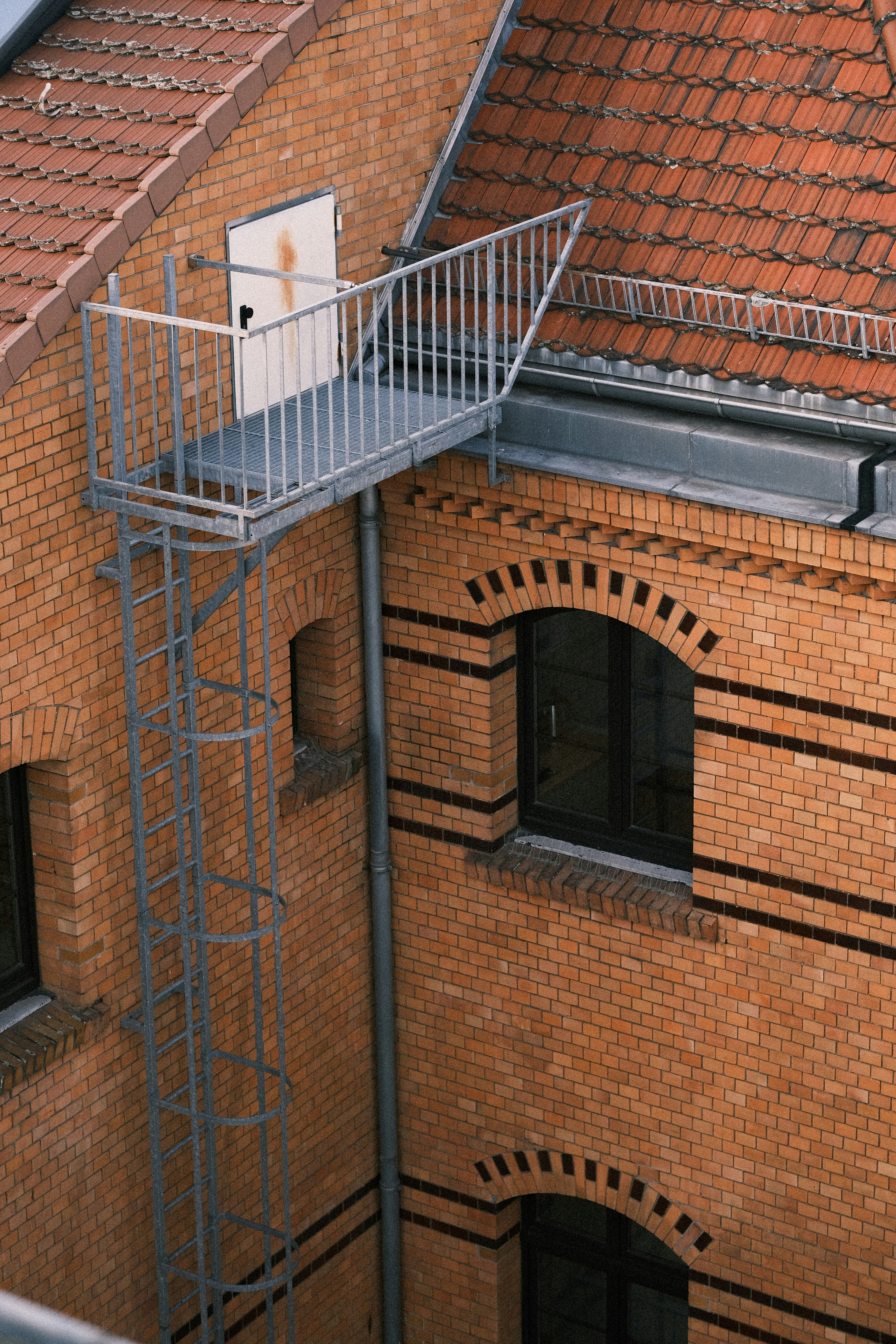 Rusted Steel Fire Escape Clinging to Brick Facade