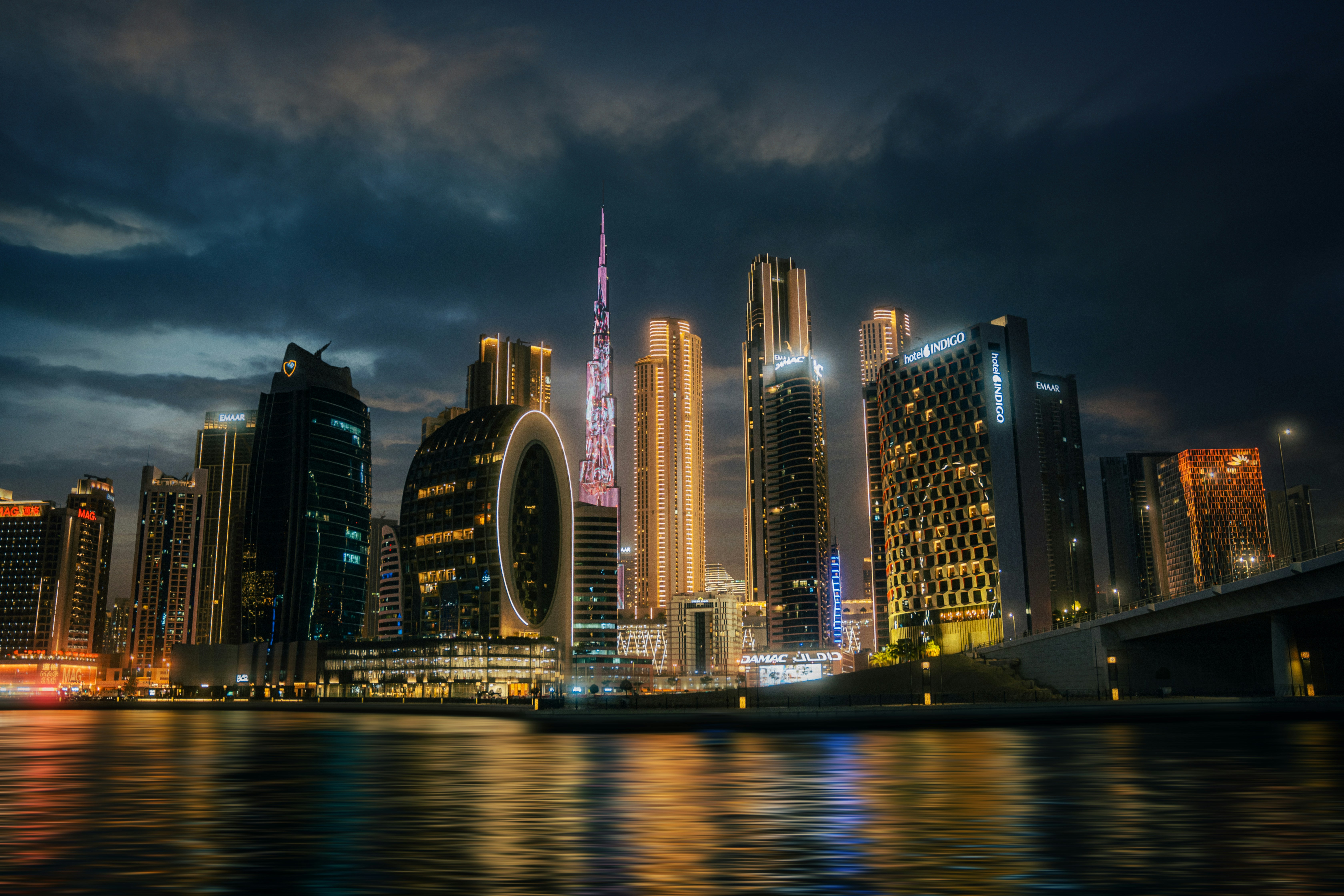 A night scene of a city with skyscrapers and a bridge photo – Free City ...