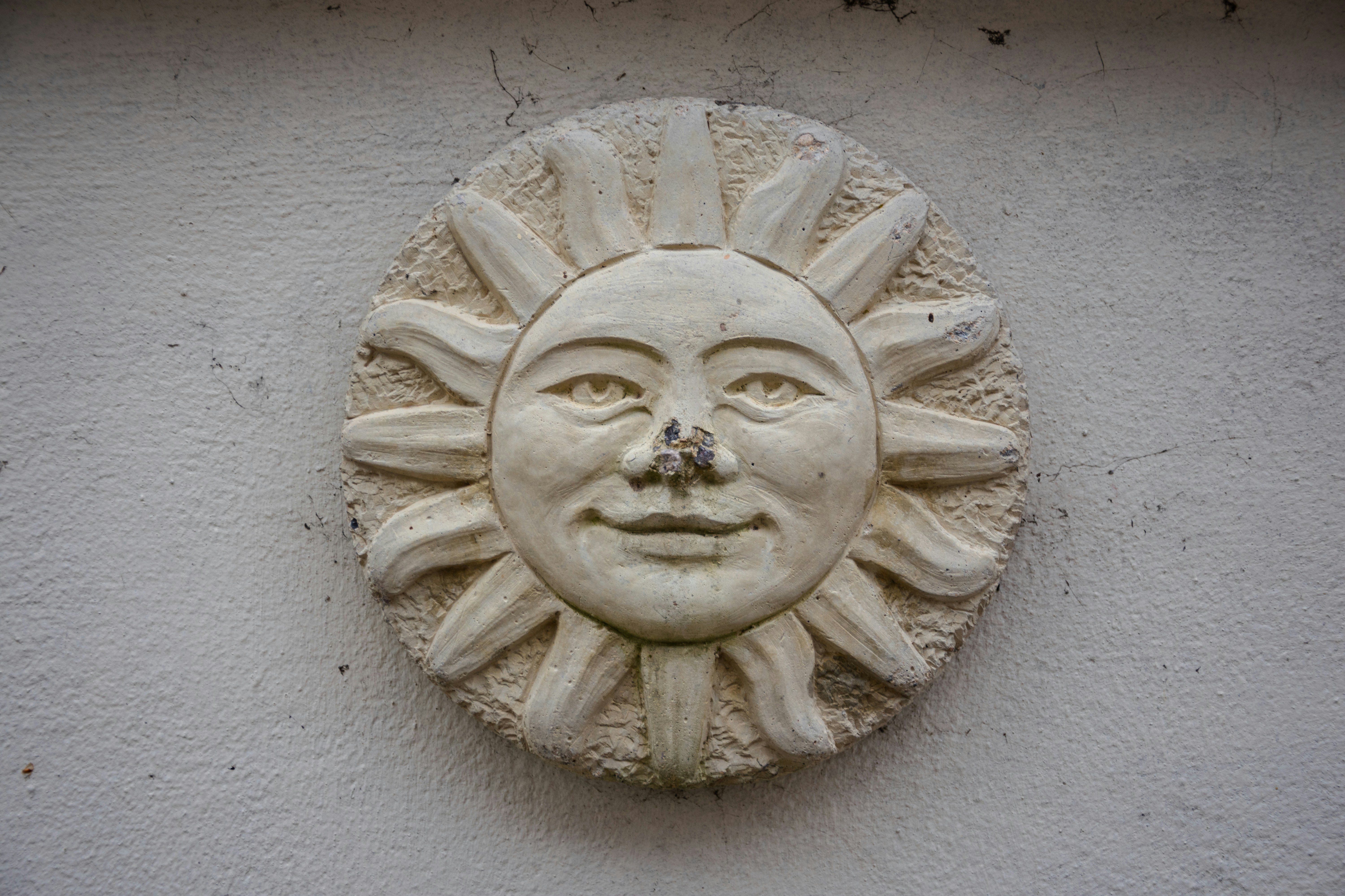 A sun face on the side of a building photo – Free Art Image on Unsplash
