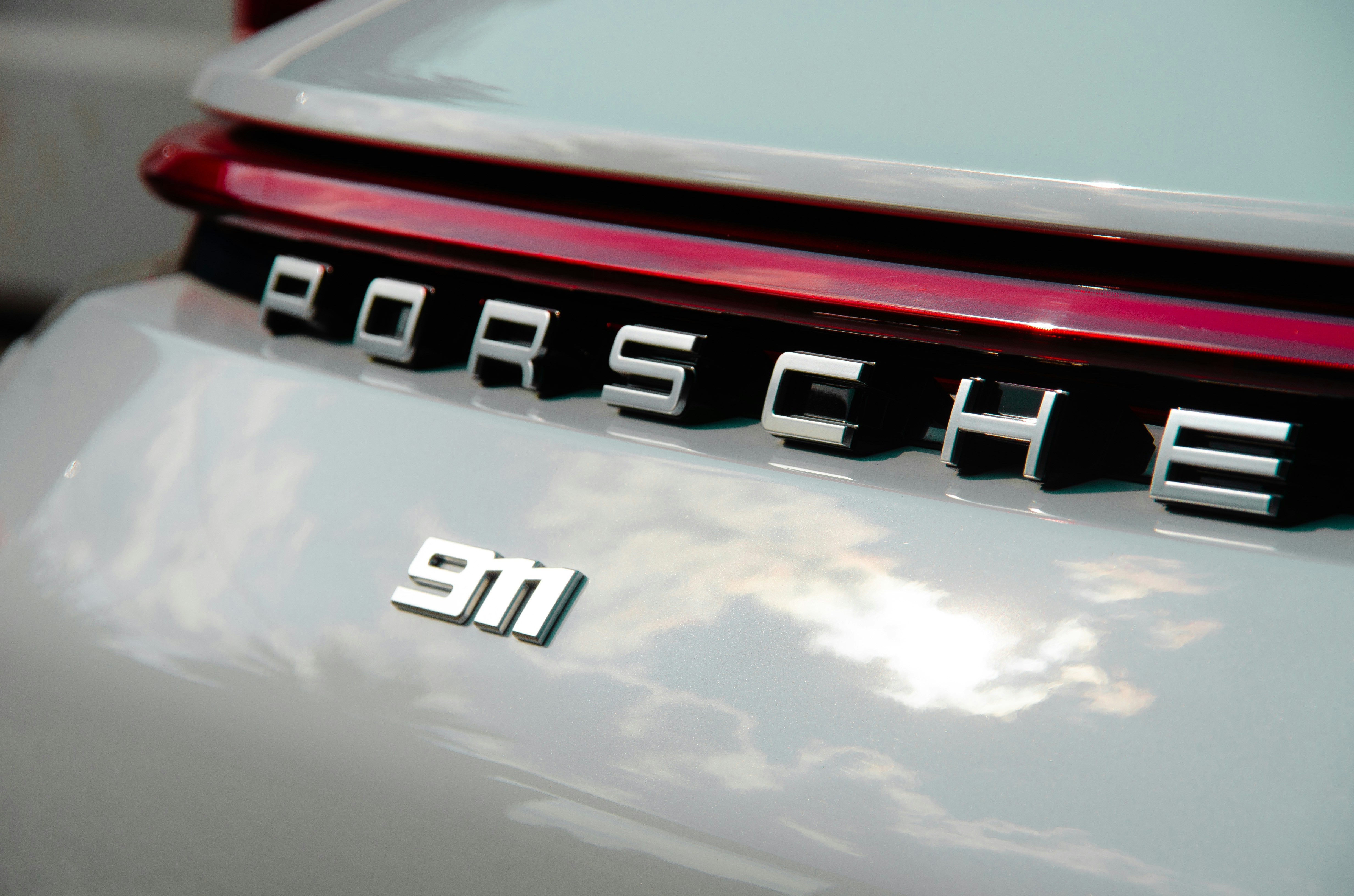 Chrome Script and Sky Reflections on a Powder-Blue Porsche 911 Trunk