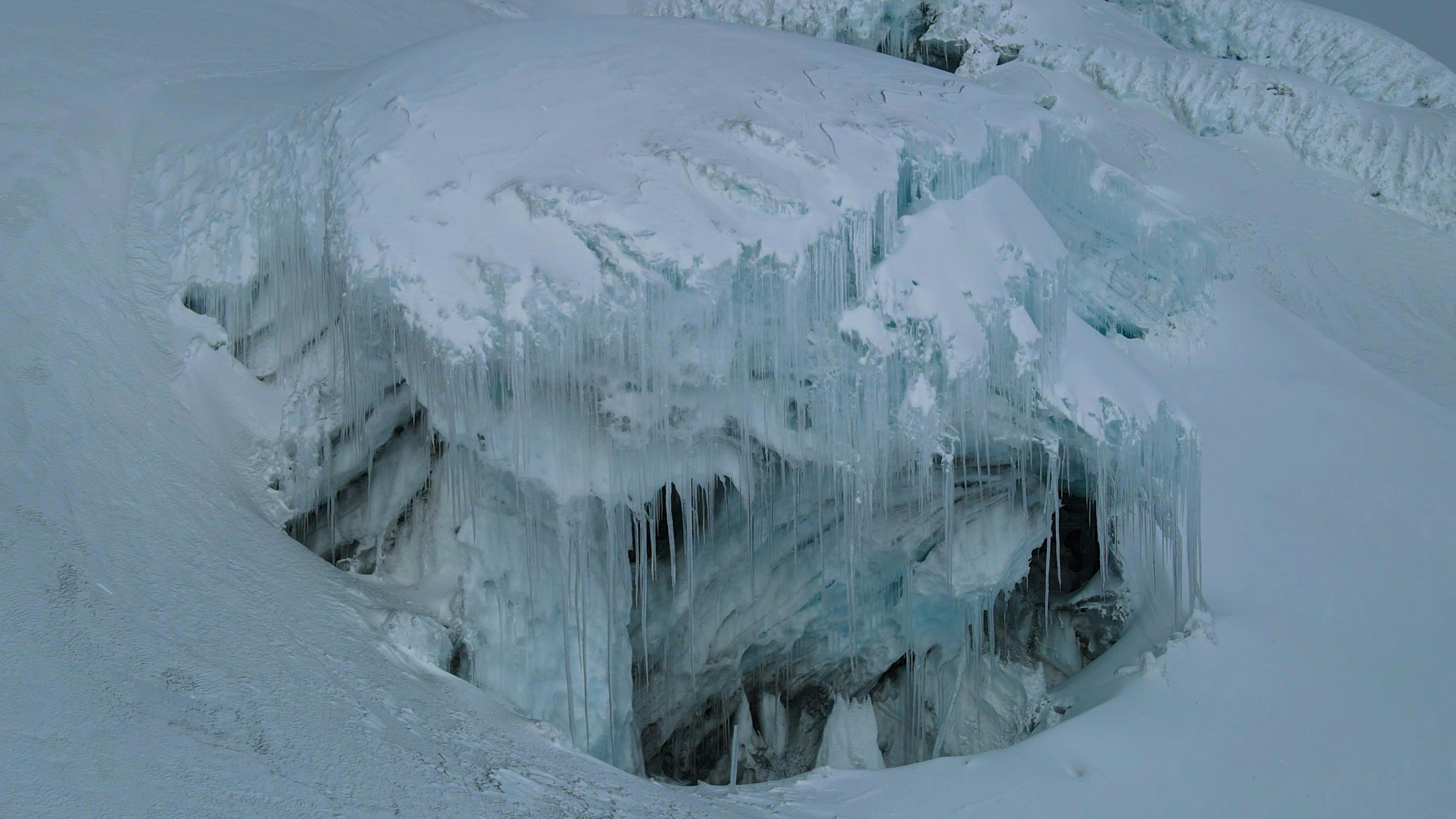 A very large ice formation in the middle of a mountain photo – Free ...