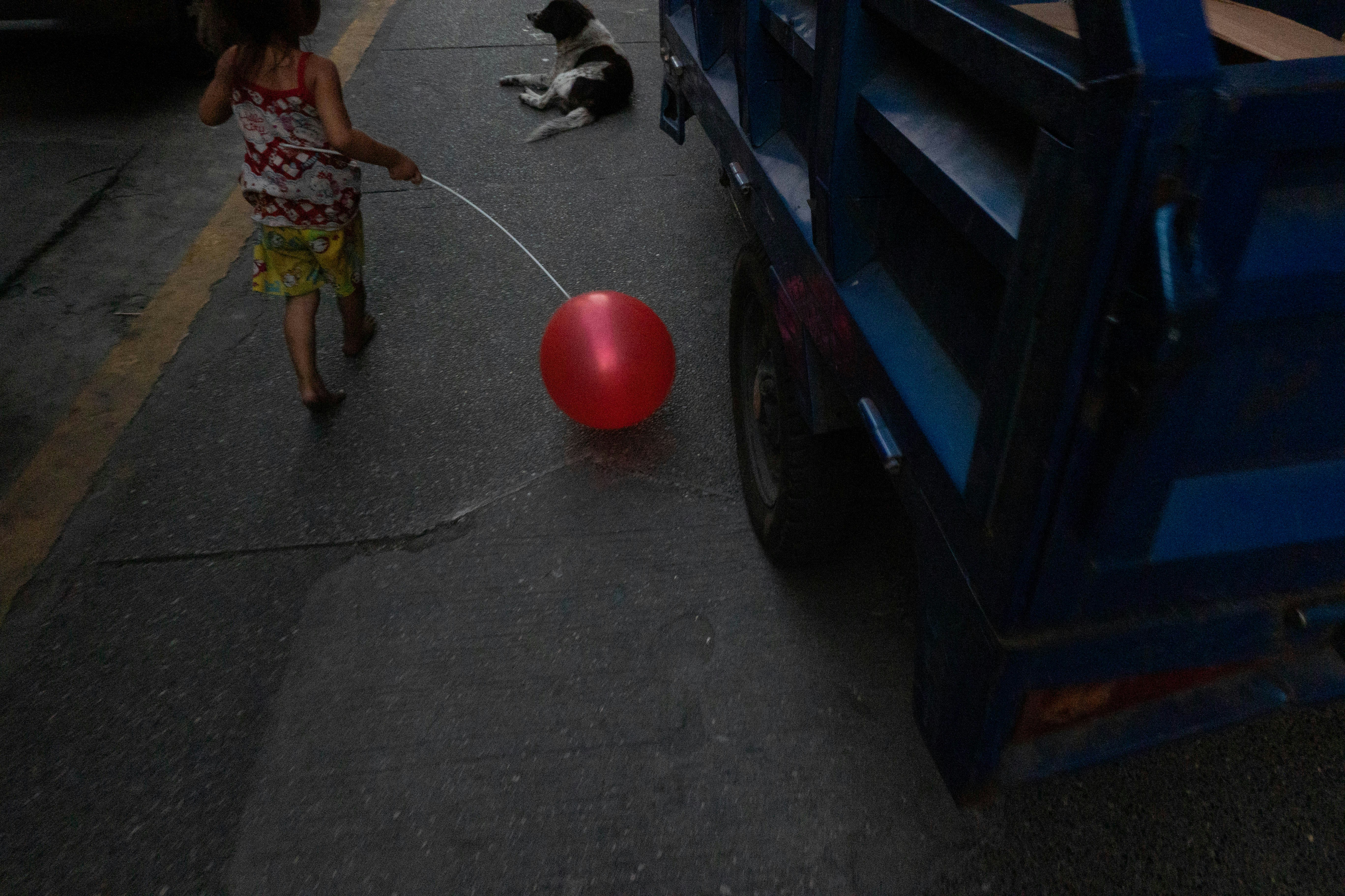 A little girl walking down a street with a red ball photo – Free Lumix ...