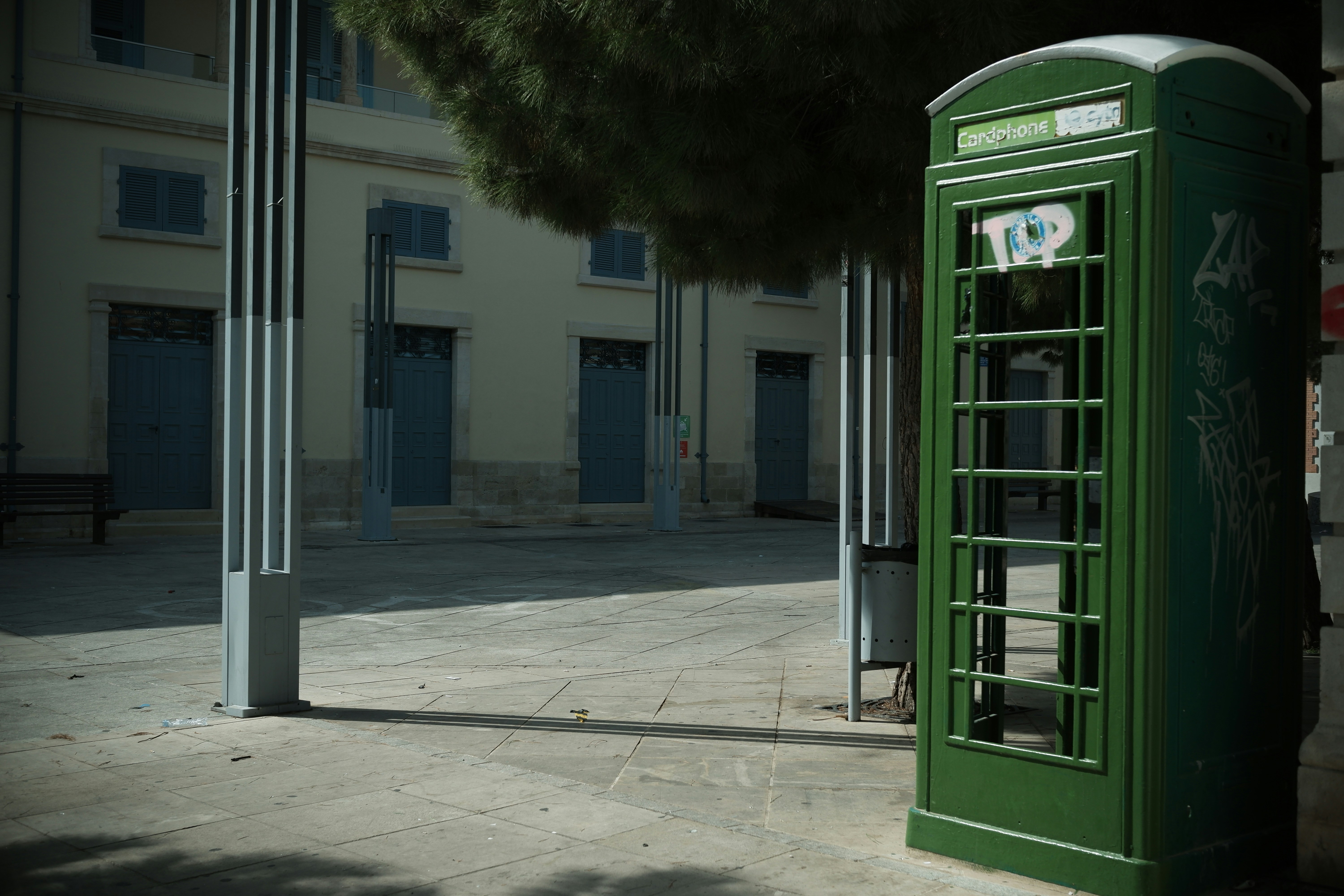 A green phone booth sitting on the side of a road photo – Free Cyprus ...