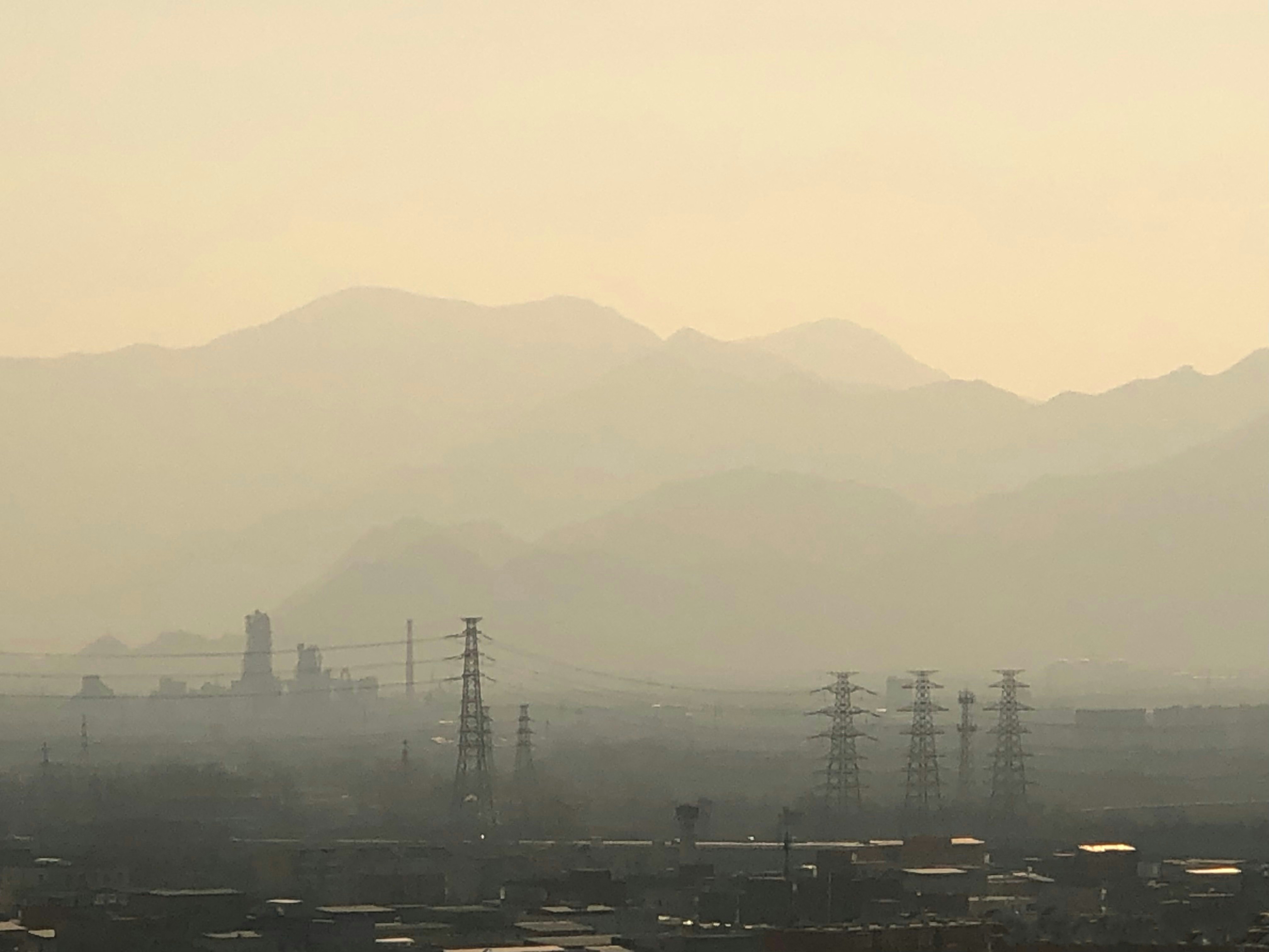 A hazy view of a city with mountains in the background photo – Free ...
