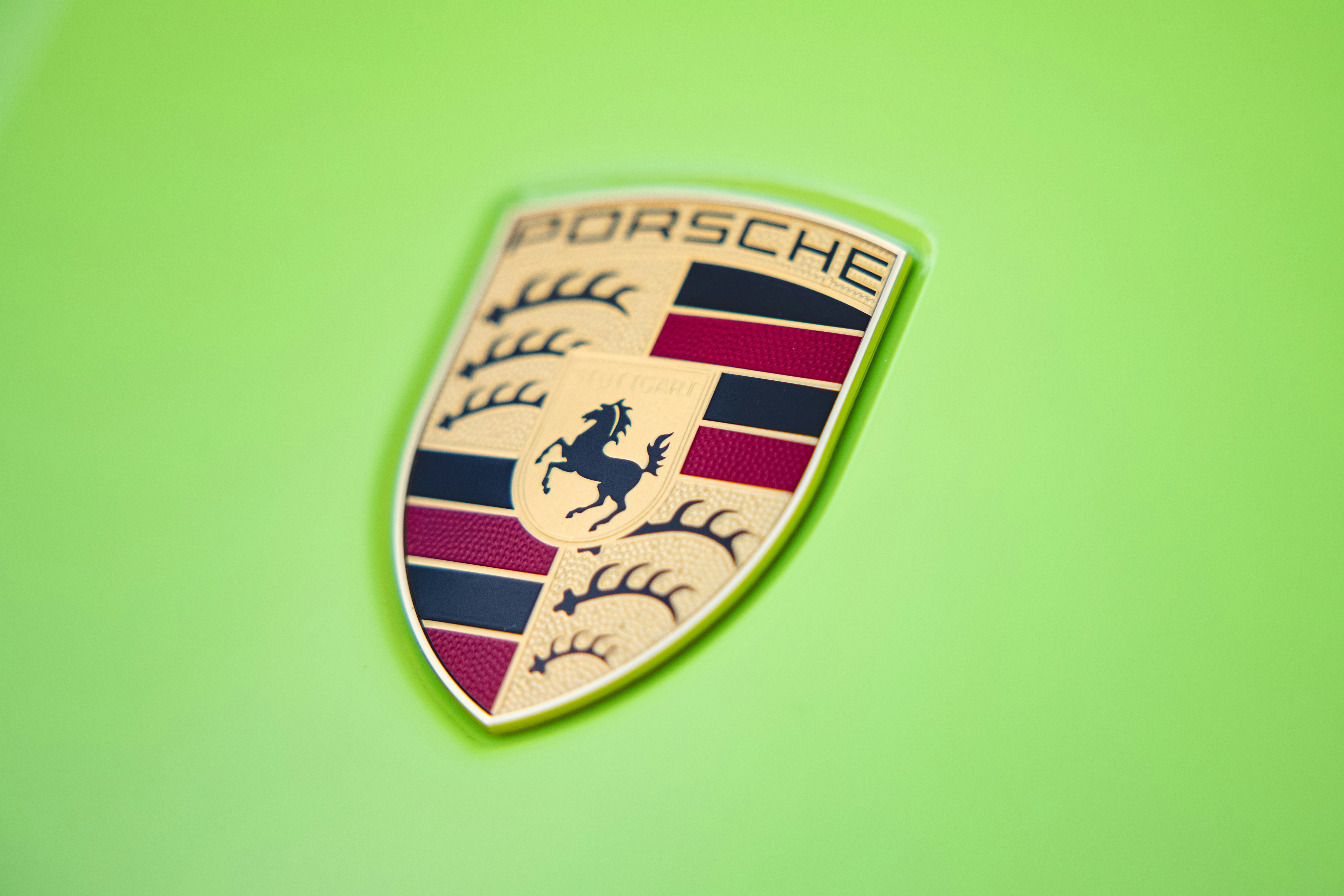 A close up of a porsche emblem on a green background photo – Free Logo ...