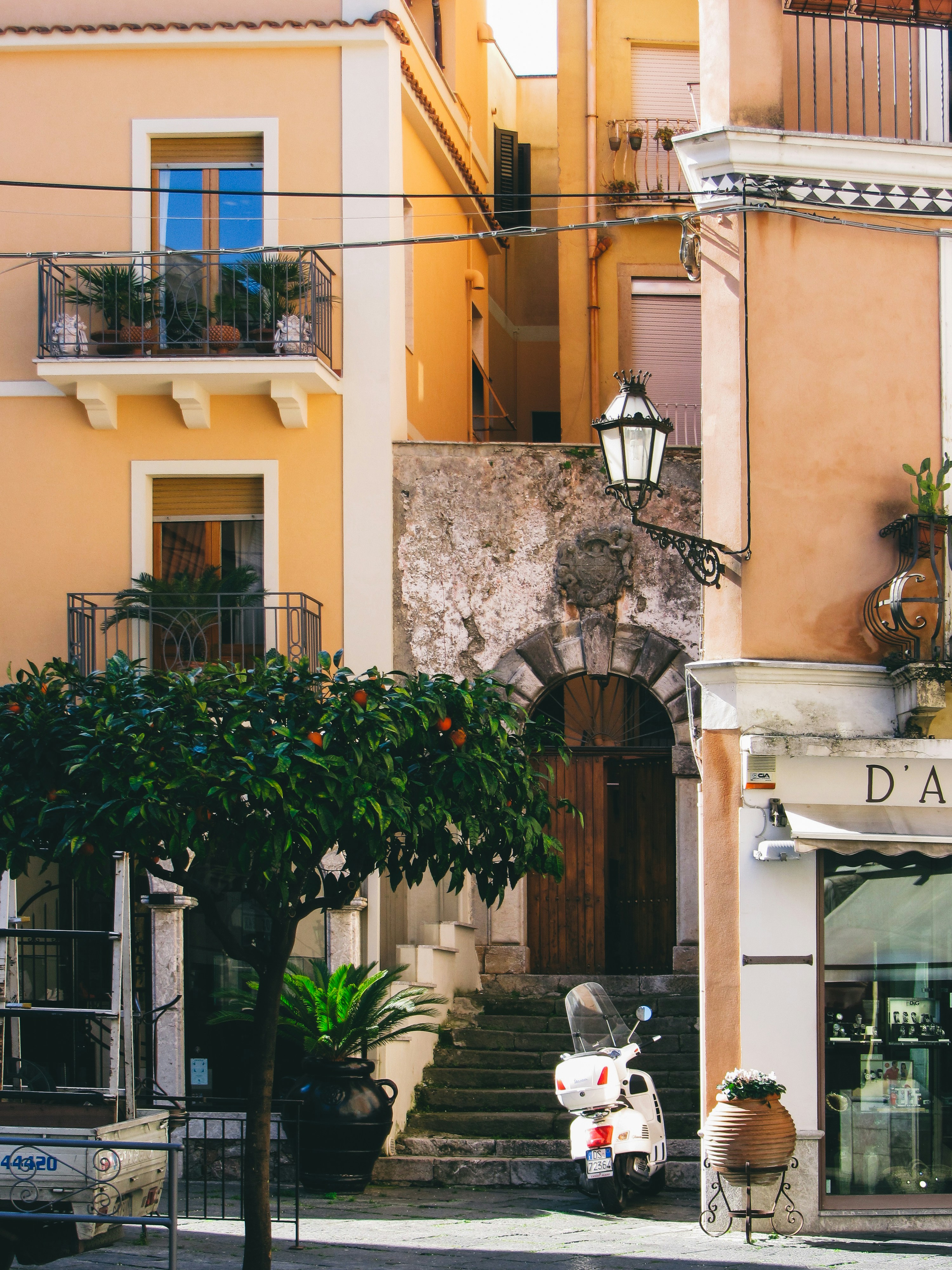 Street view in Taormina | a scooter is parked in front of a building