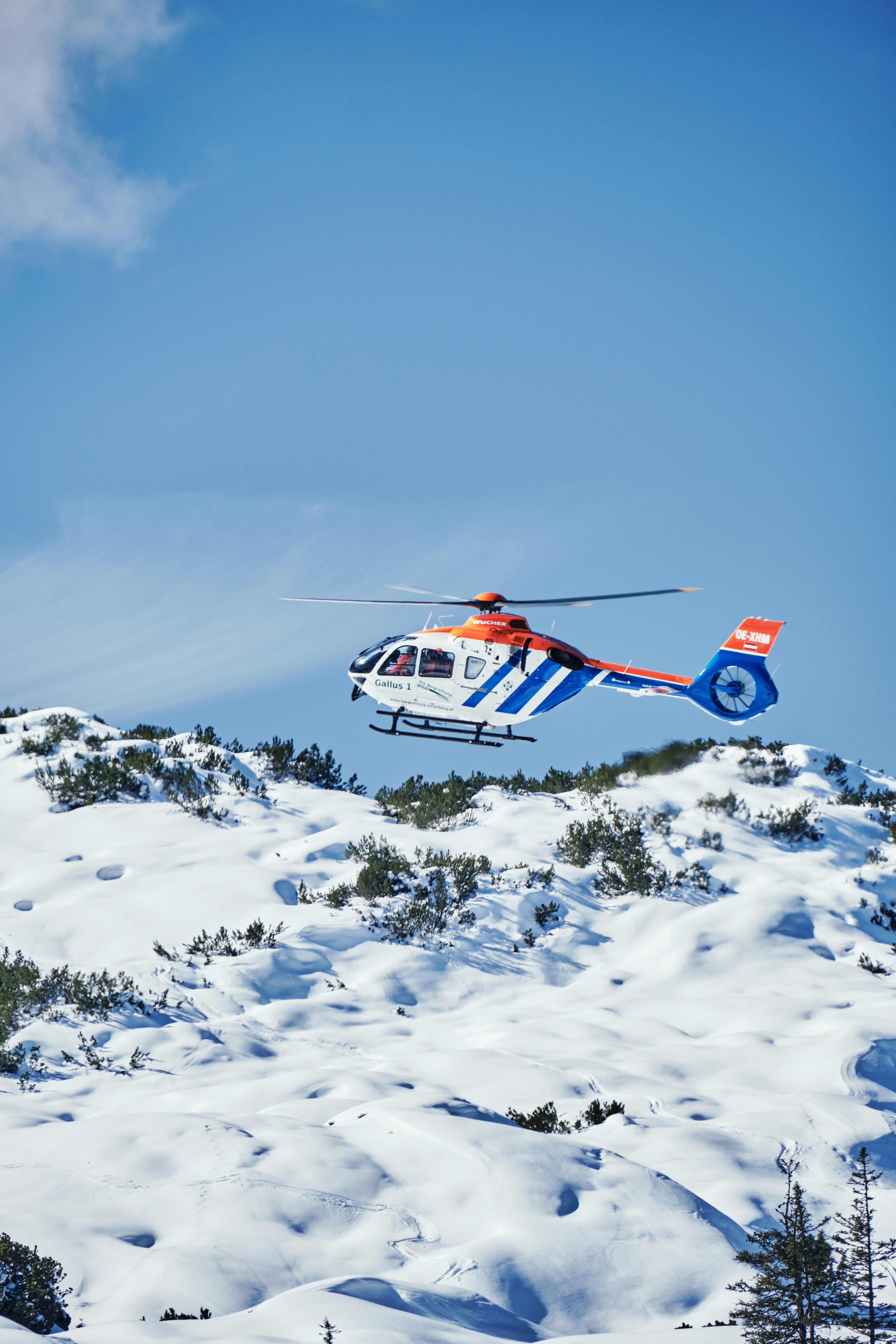 A helicopter flying over a snow covered mountain photo – Free ...