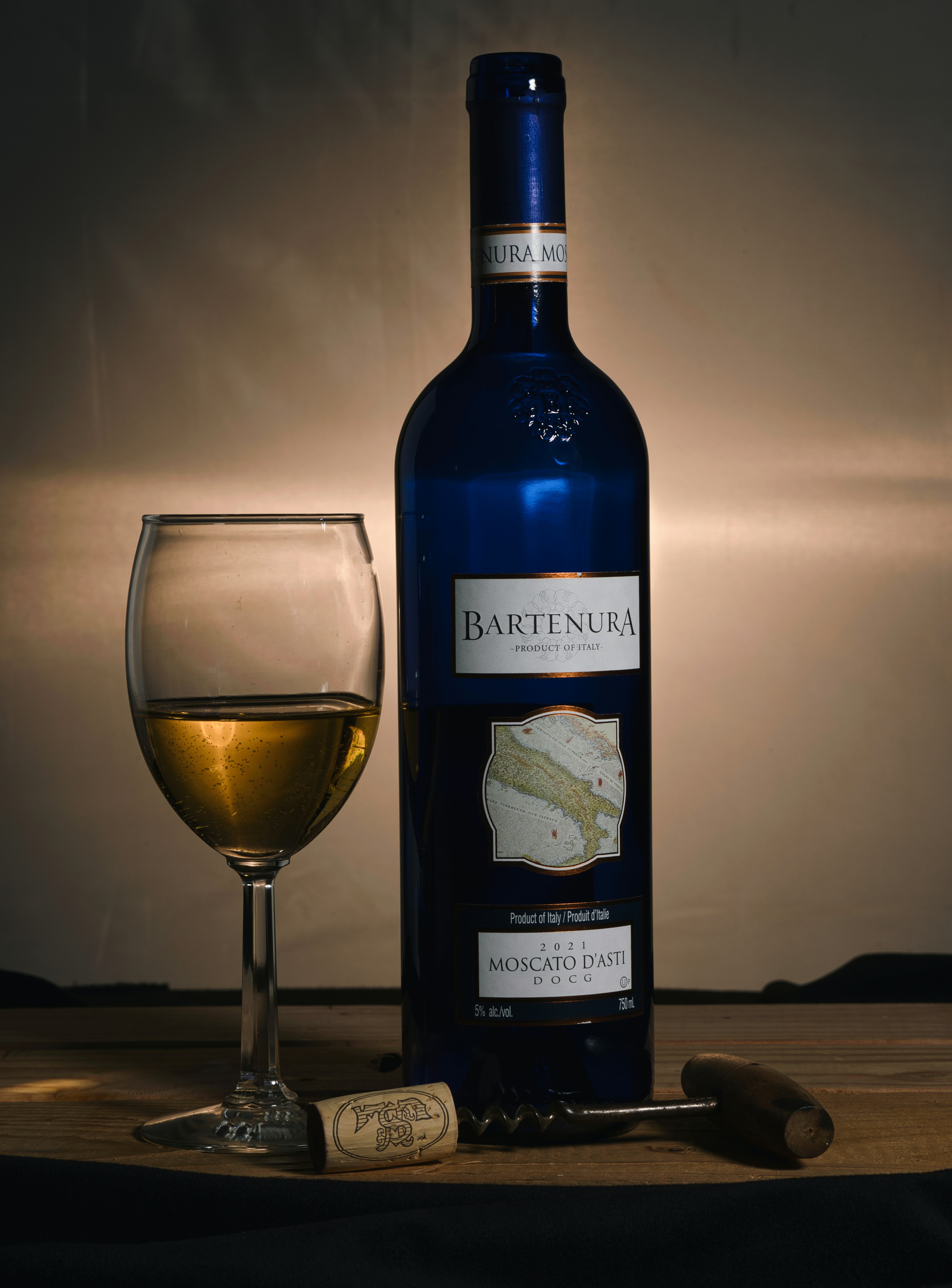 Indigo Moscato in Soft Backlight: A Still Life with Bottle, Glass, and Corks