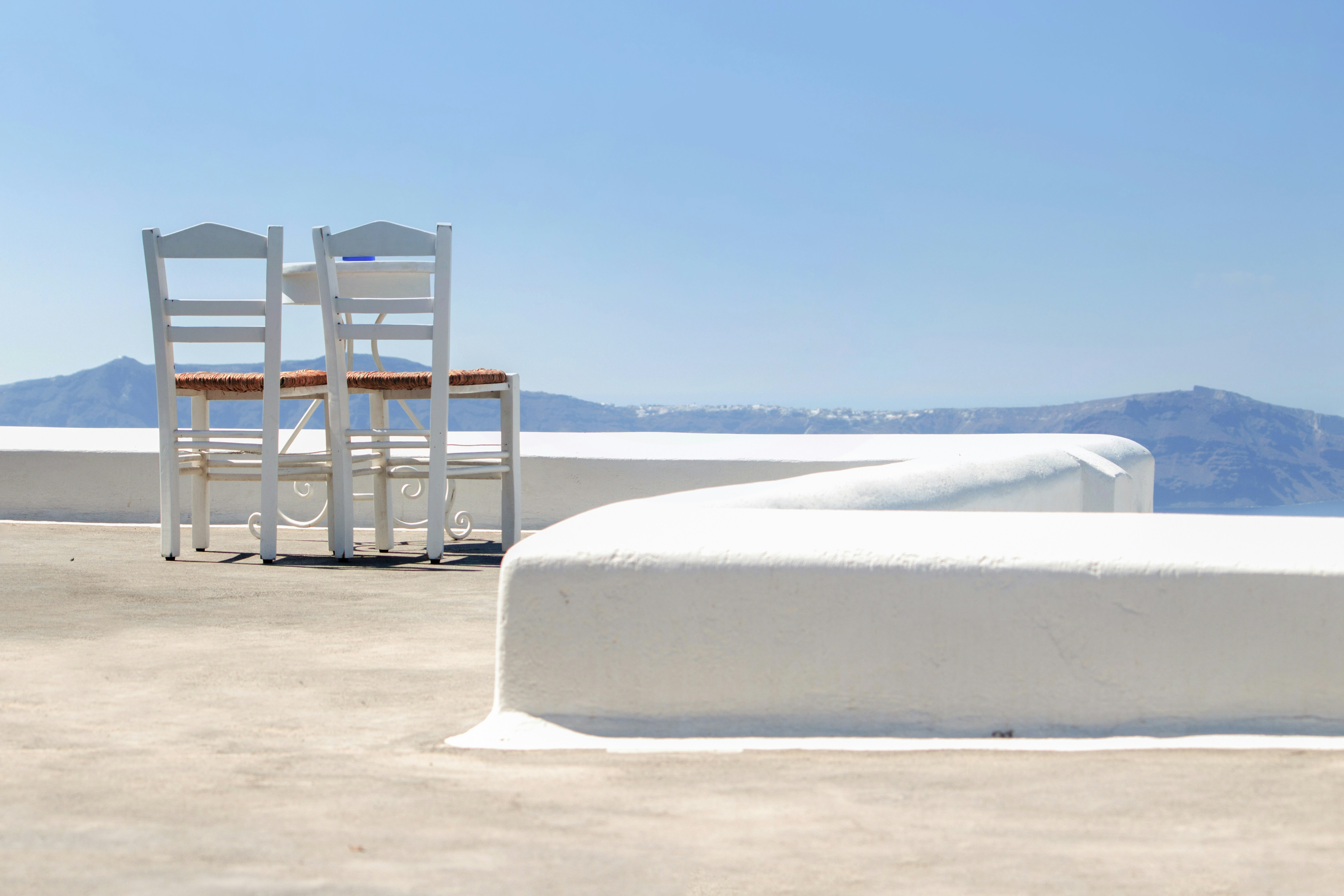 a couple of white chairs sitting on top of a roof