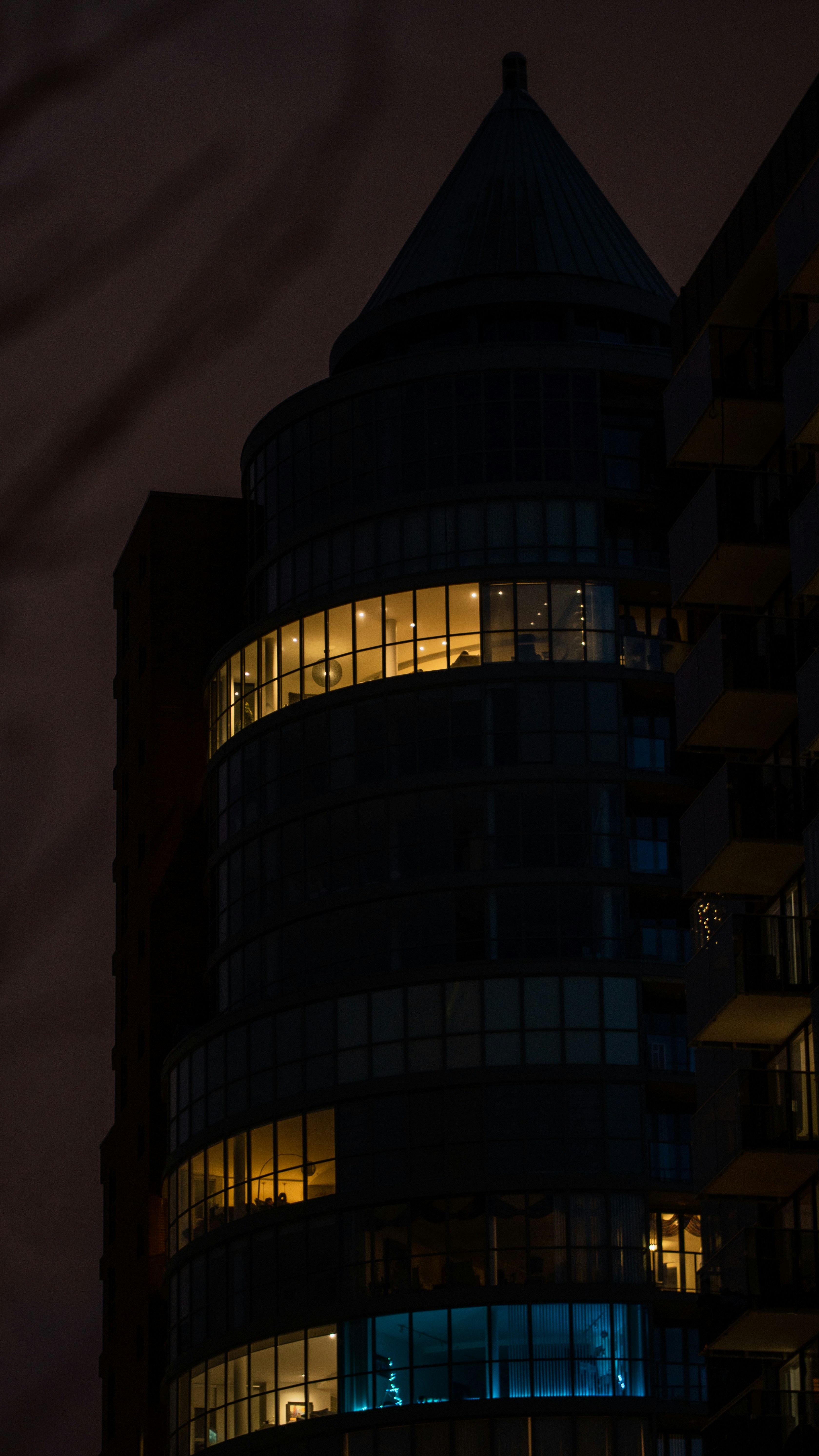 Arc of Warm Windows on a Night Glass Tower