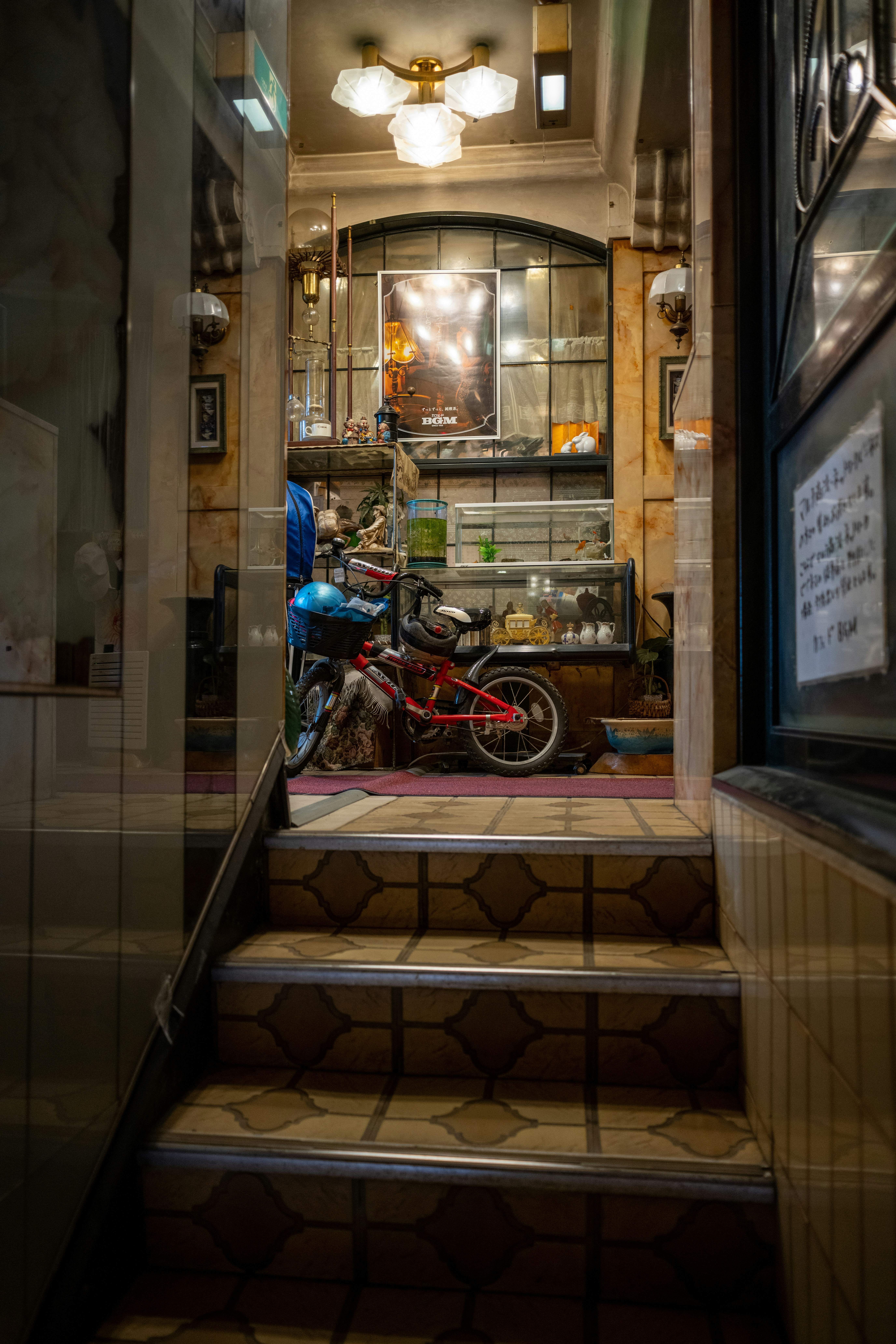 Quiet Shopfront Retreat: Hidden Toys and a Redbike in a Narrow Stairwell