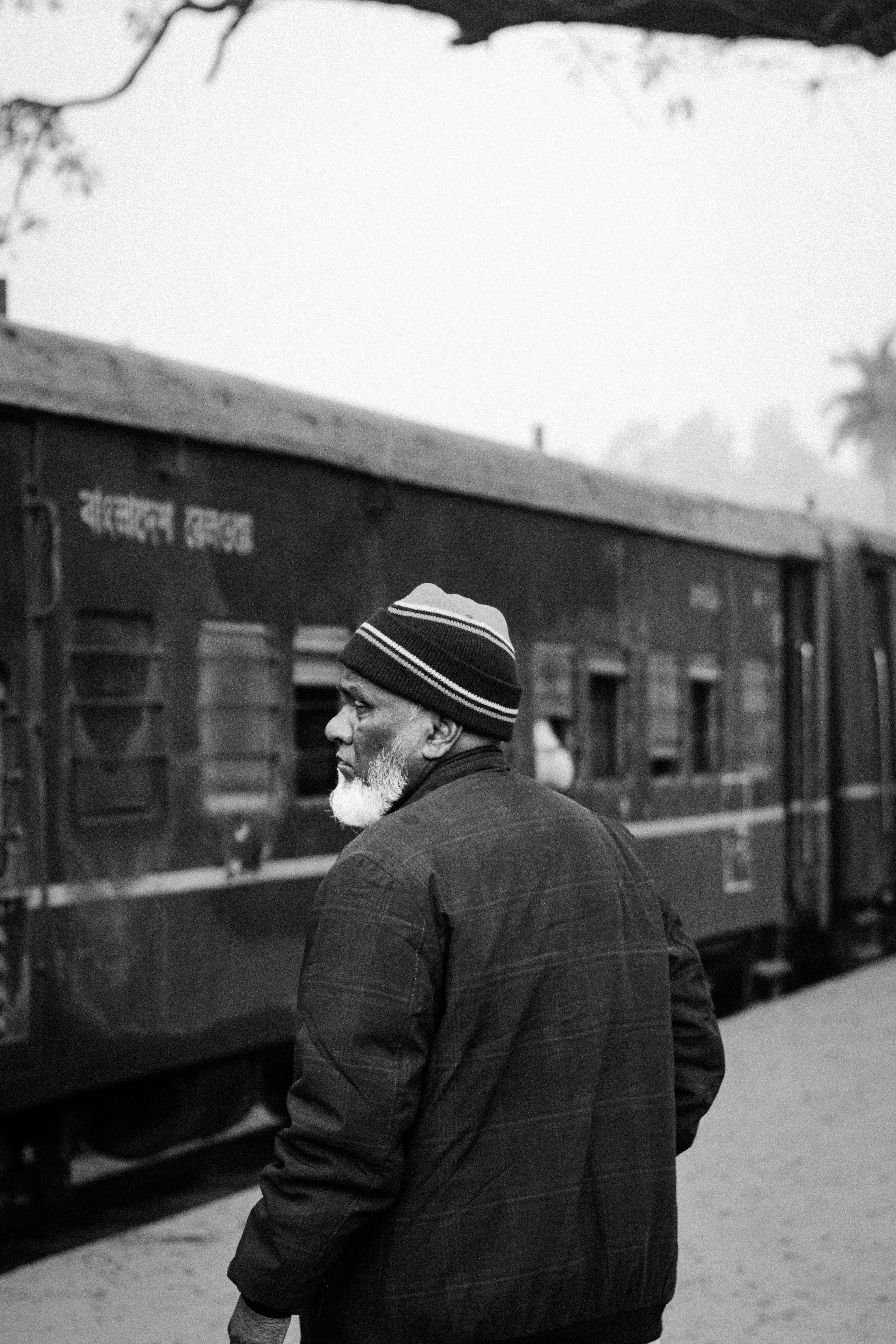 a man standing next to a train on a train track
