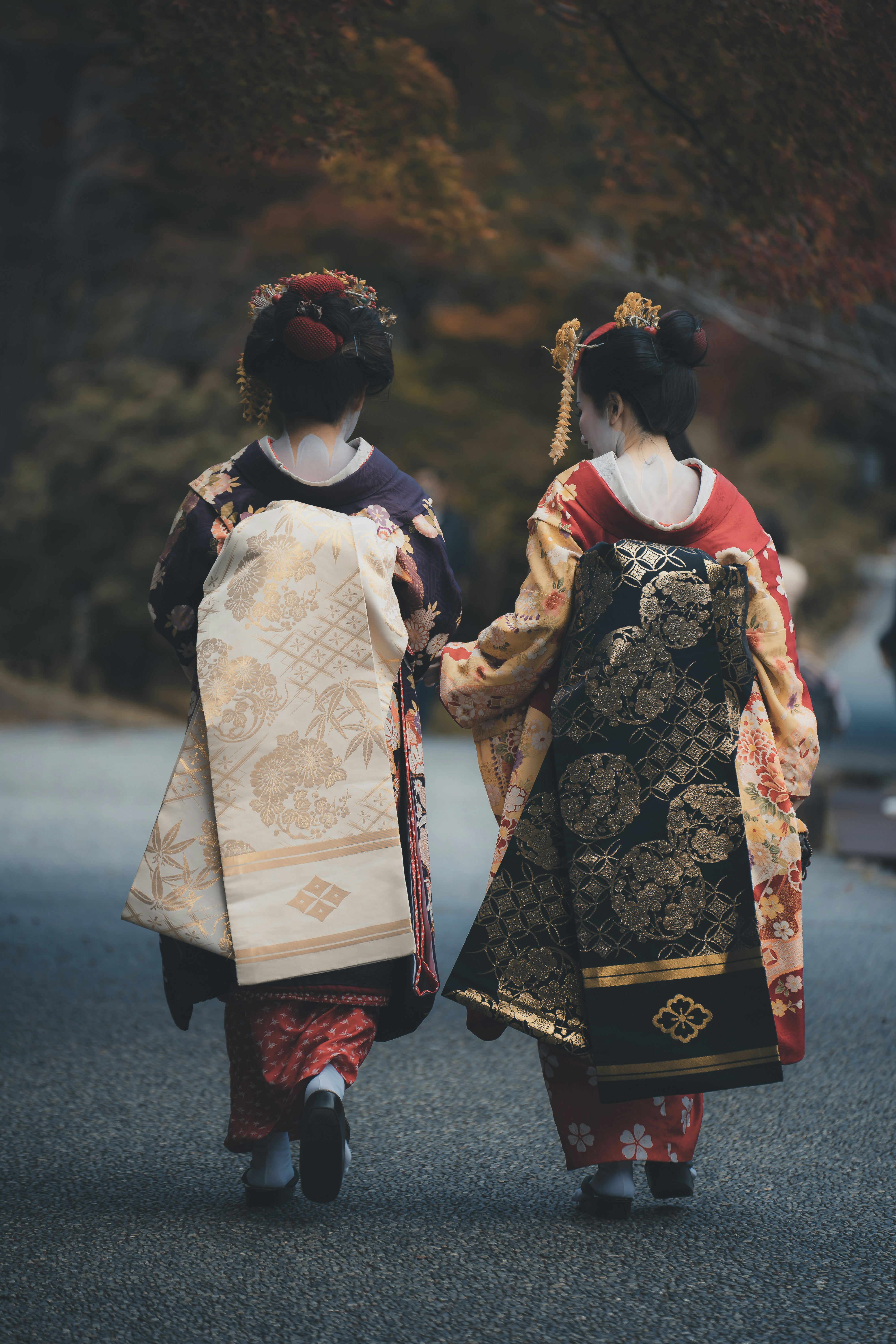 Two geisha walking down a street holding hands photo – Free Japan Image on Unsplash